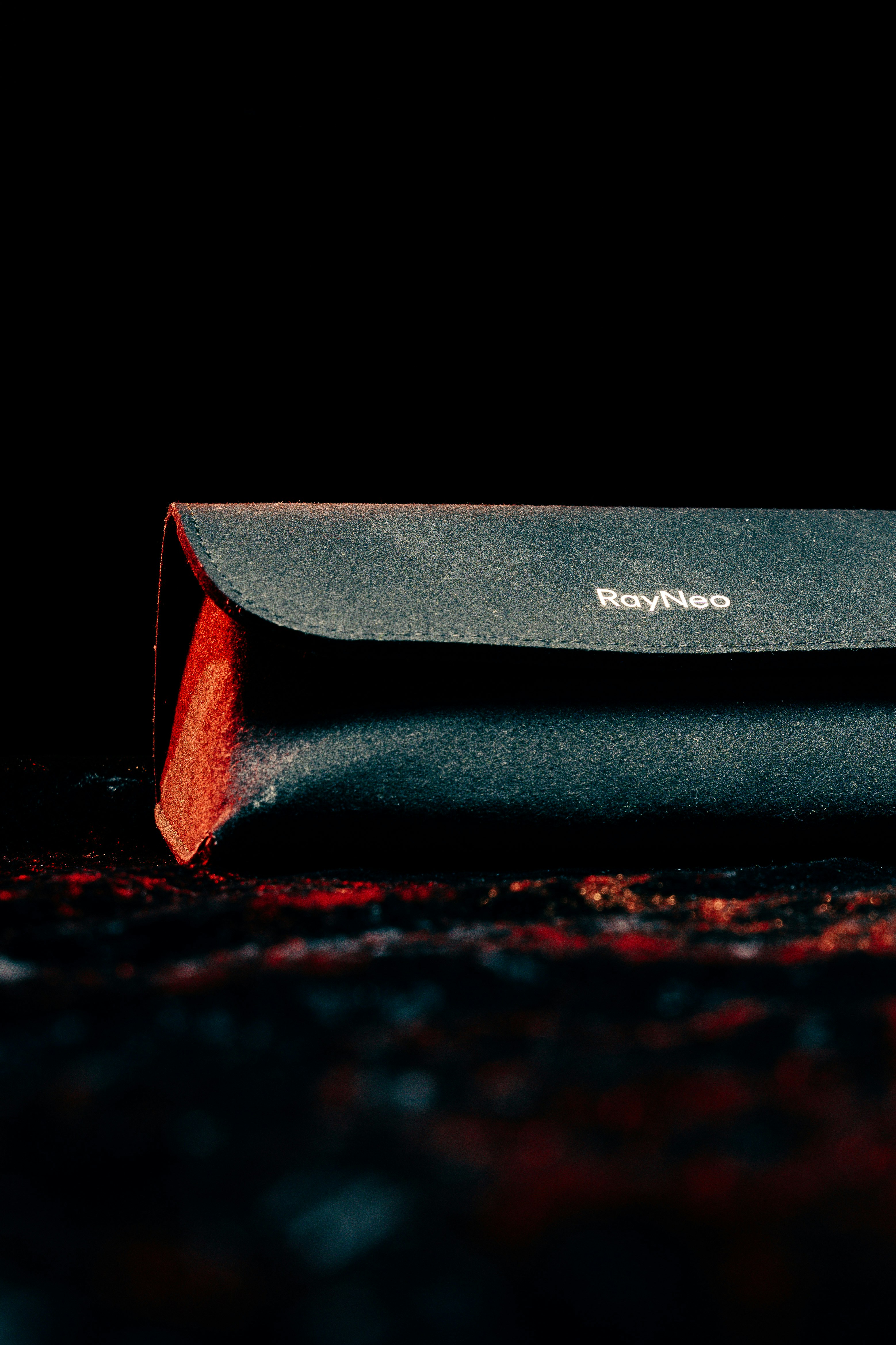 Red Hideaway: A RayNeo Wallet Resting in Velvet Darkness