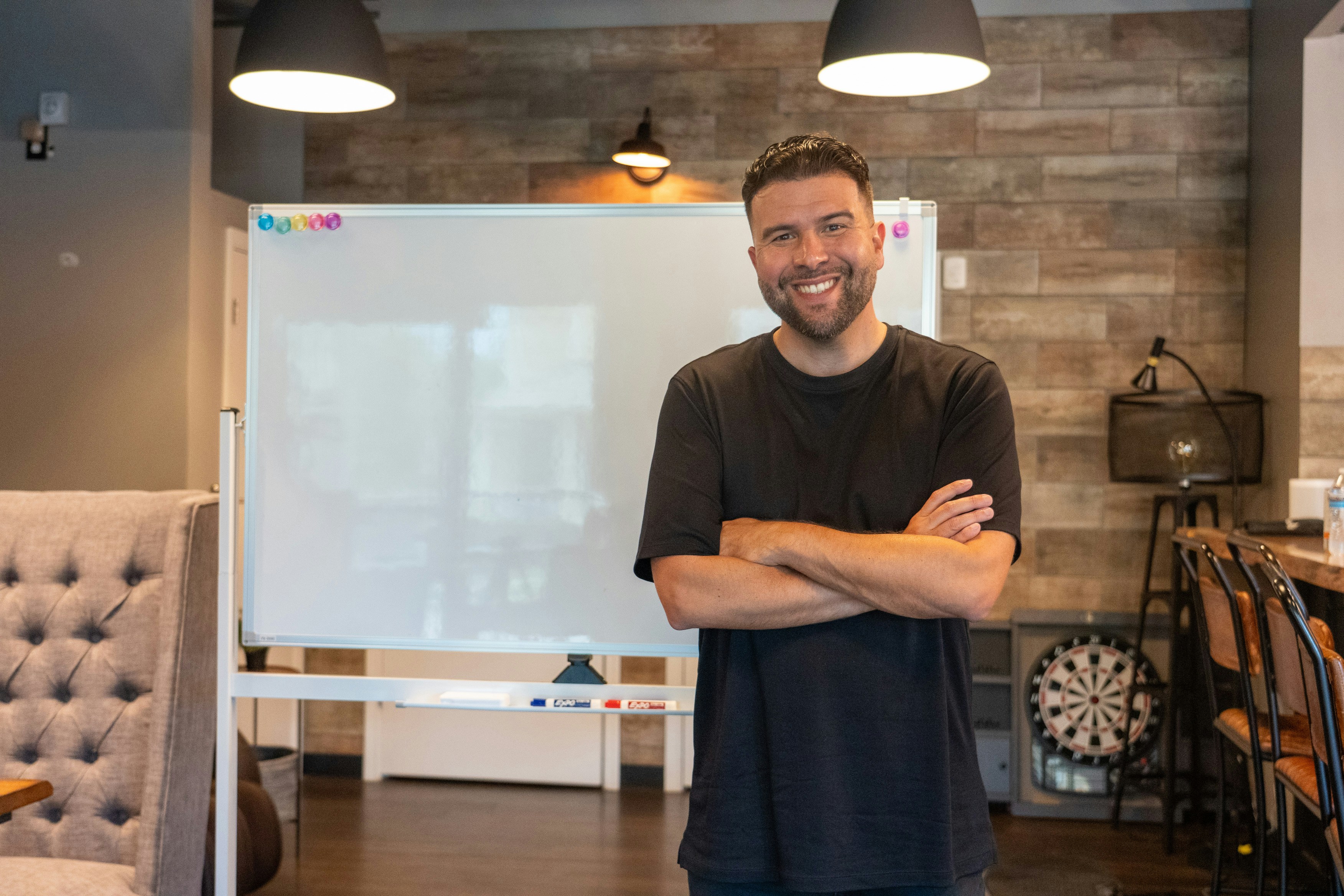 Smiling mentor in a modern coworking space with a whiteboard