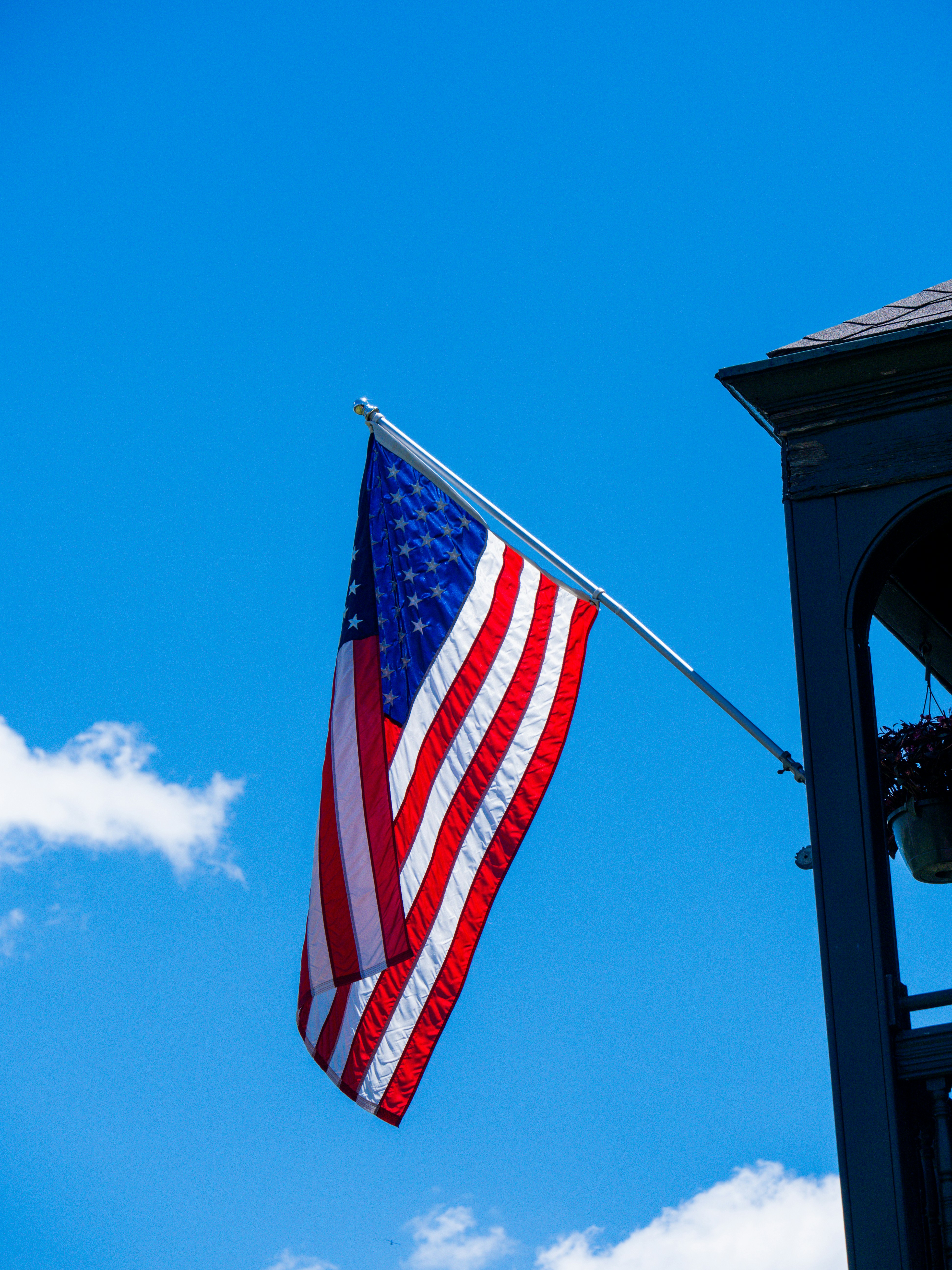 Flag on a Tilted Pole Against a Clear Blue Sky
