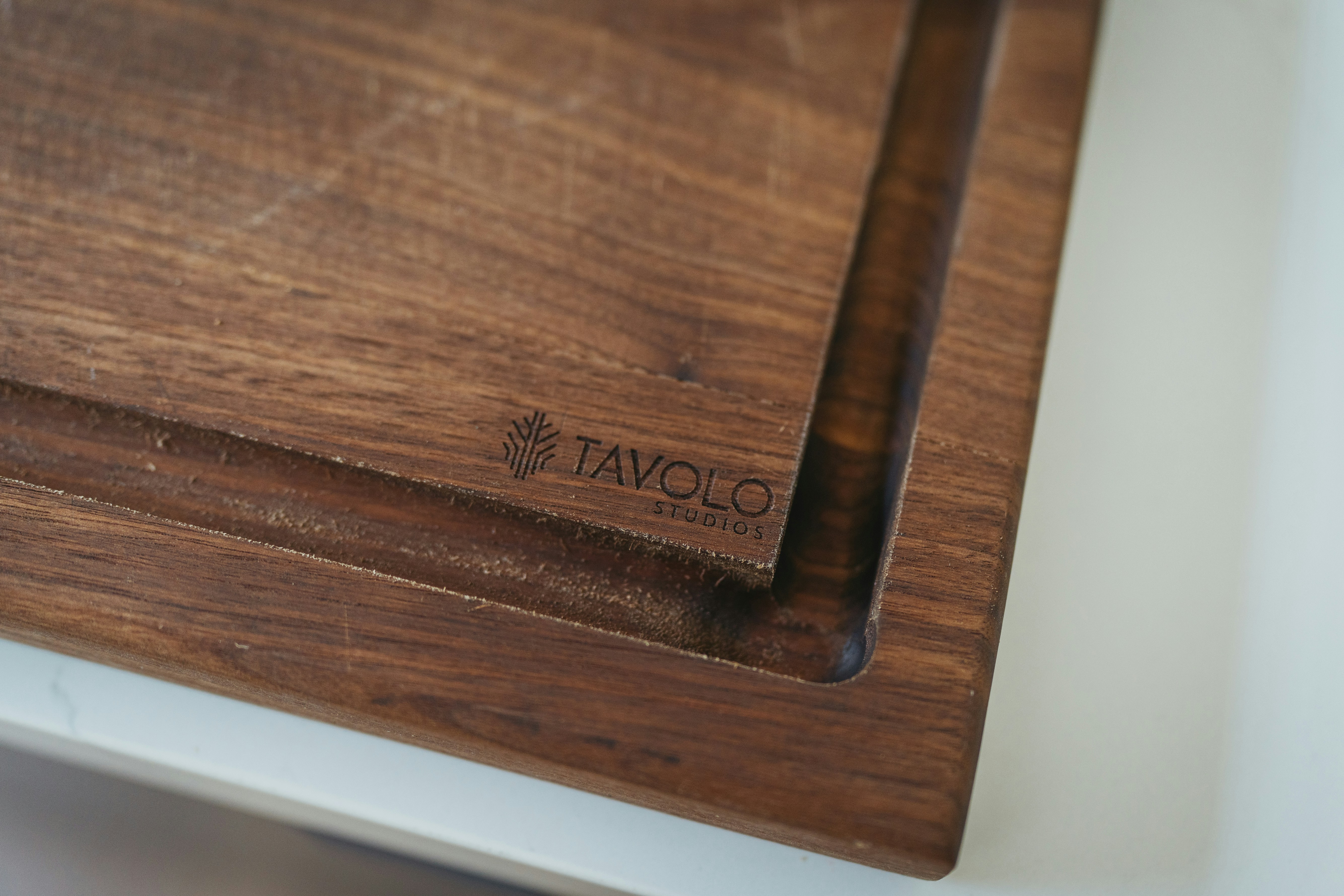Carved Walnut Corners: A Studio Logo Nestled in Wood