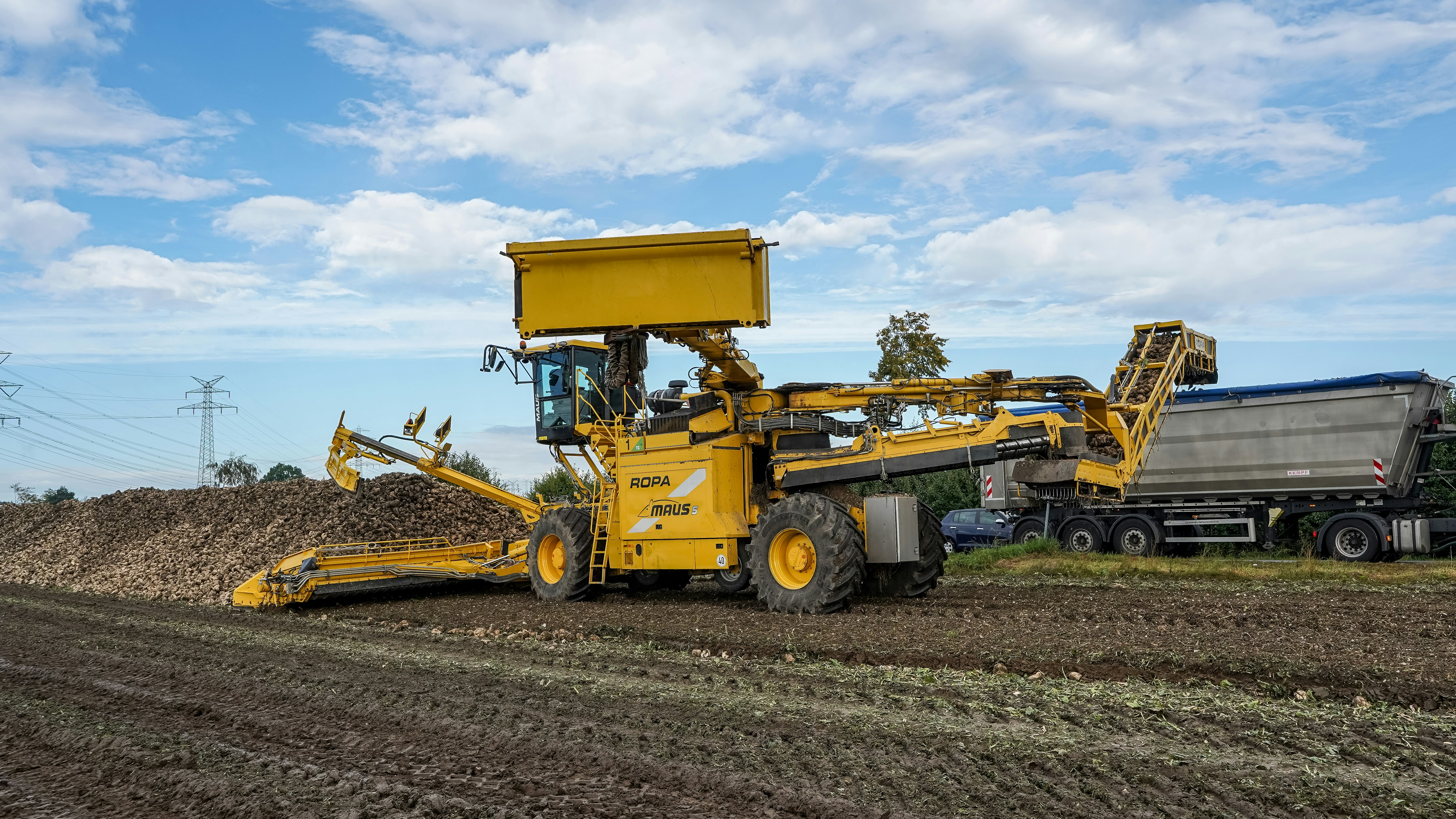 Yellow harvest: a heavy duty machine at rest on a dirt field