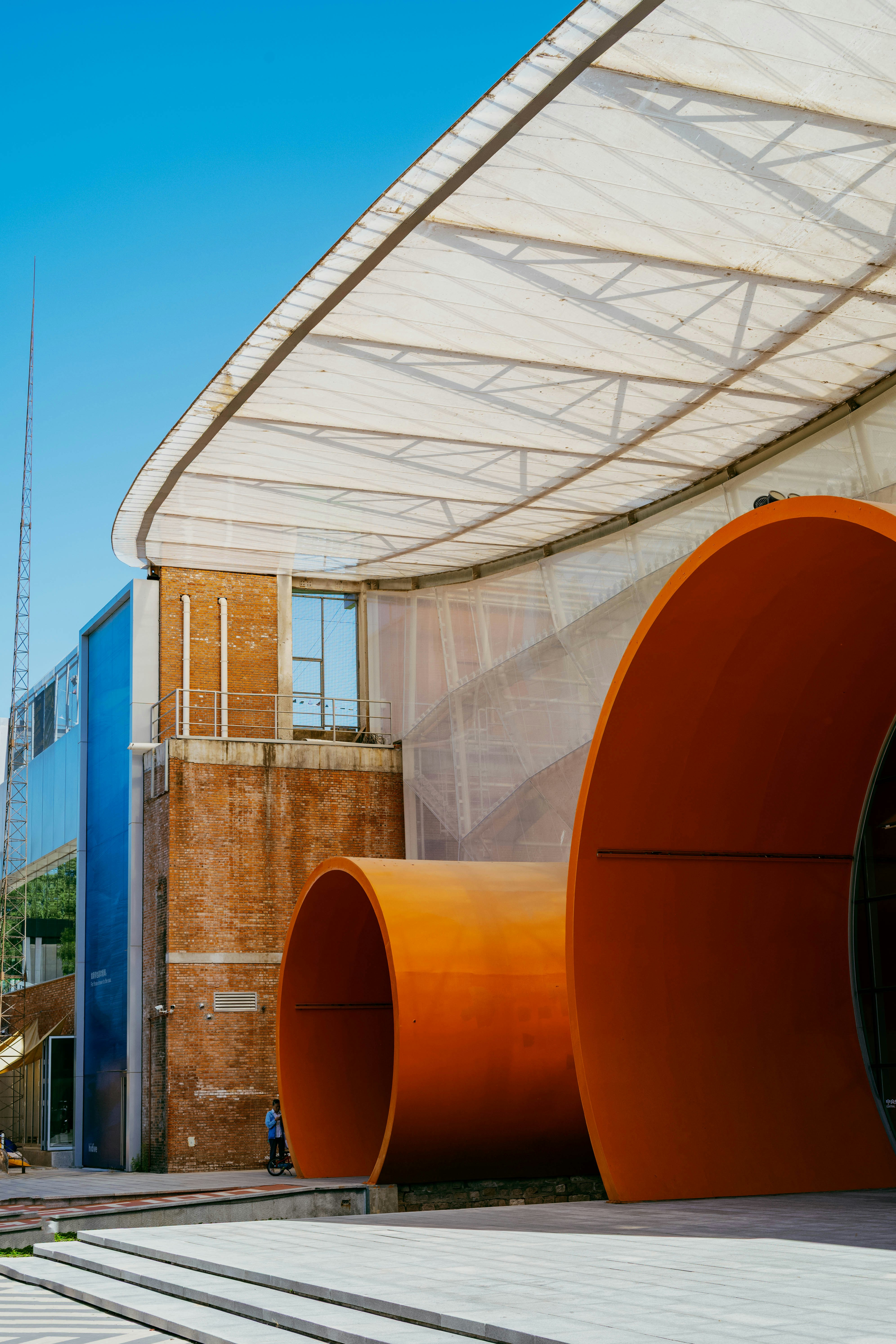 Orange Tunnel silhouettes against a glassy modern canopy