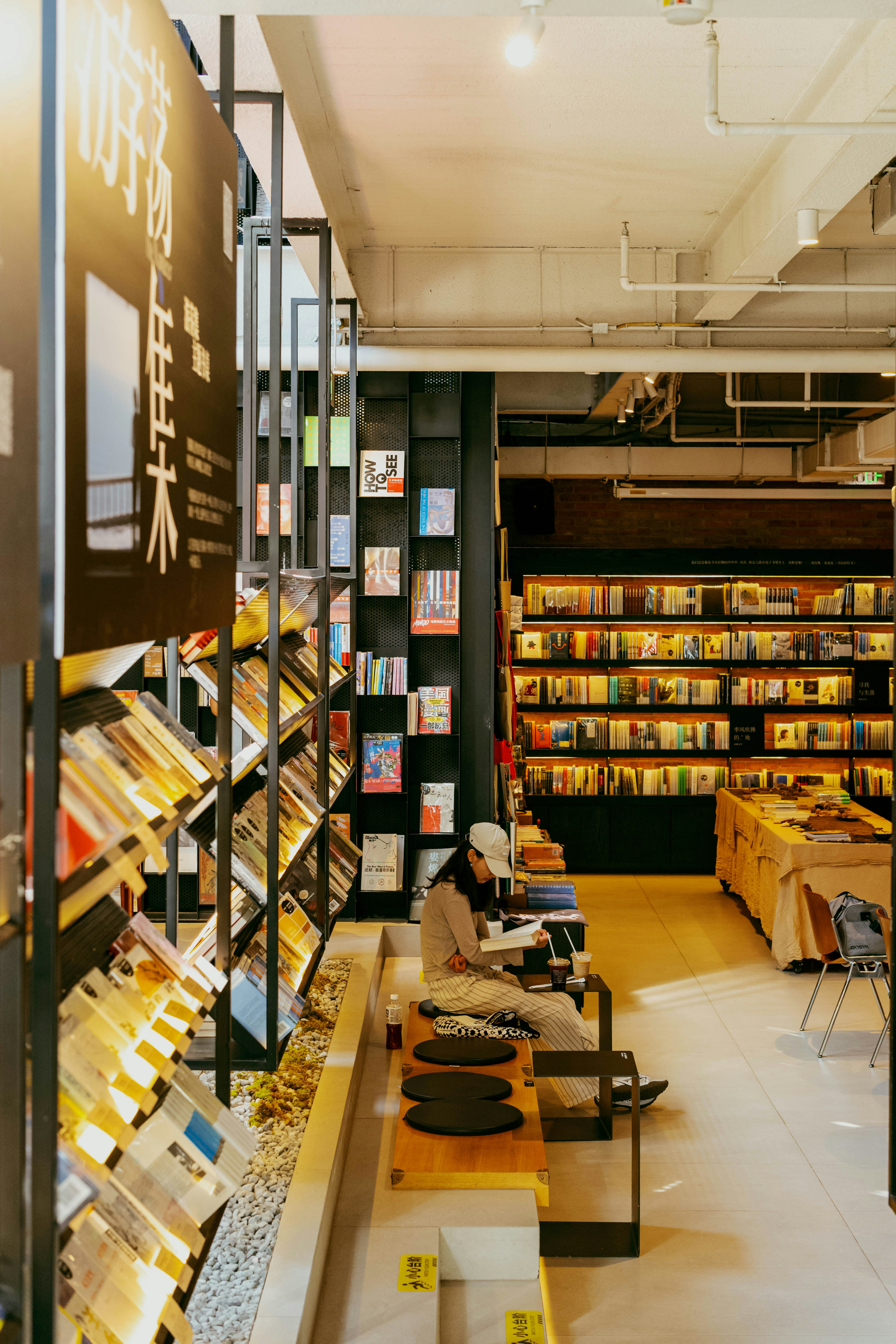 Quiet Reader in a Library Café: Pages, Wood, and Soft Light