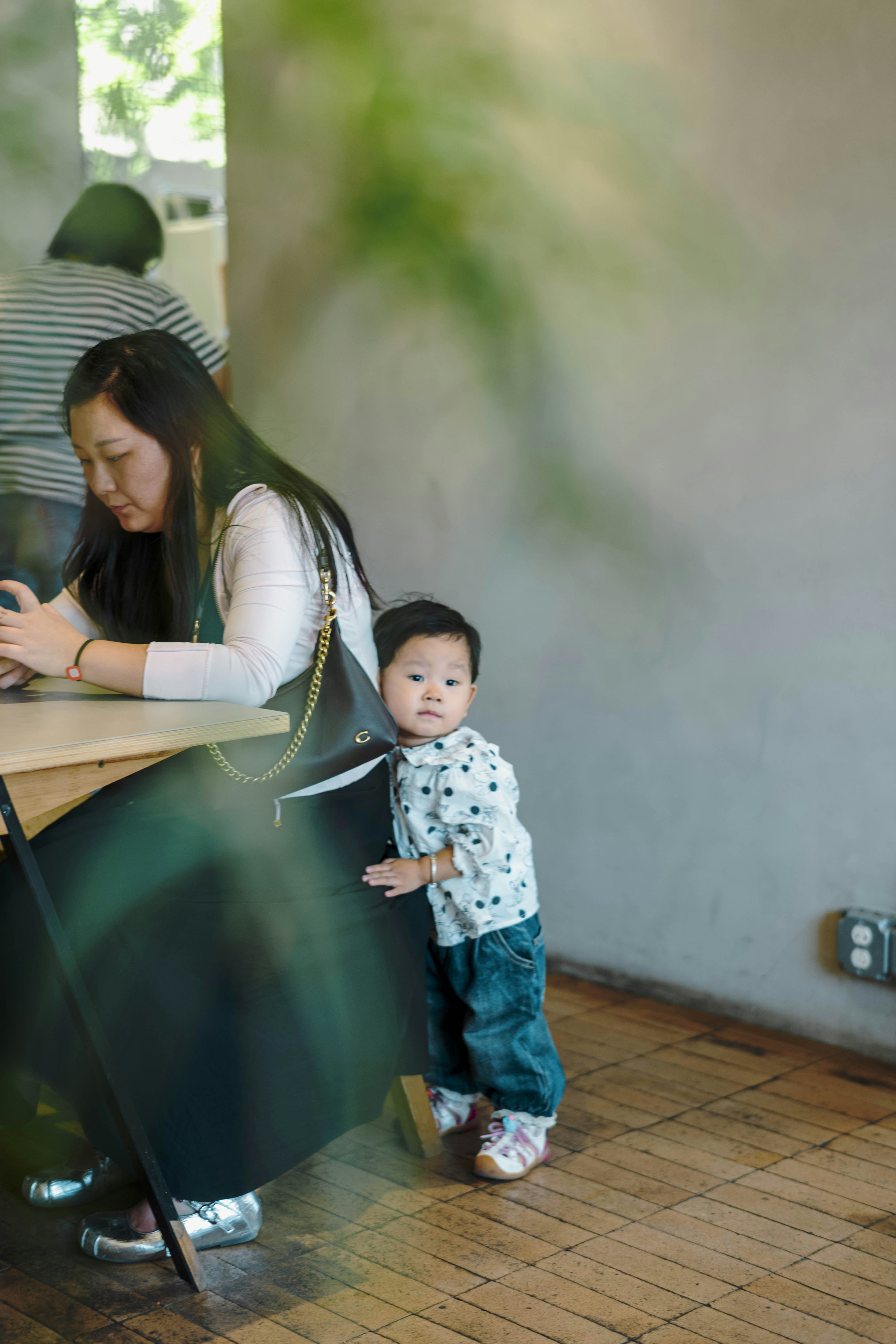 Curious toddler at a sunlit cafe table