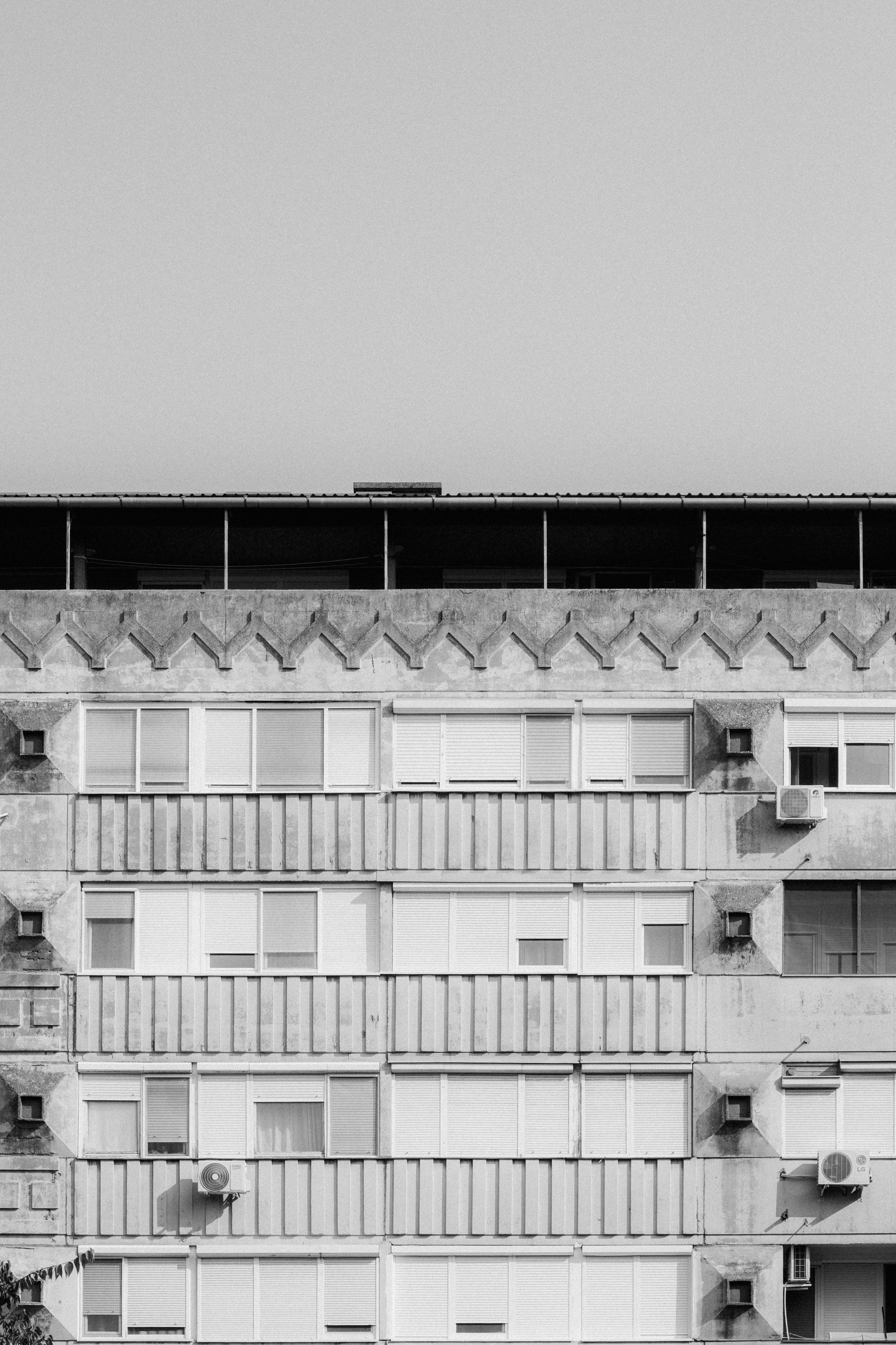 Concrete Facade in Monochrome: A Symphony of Gridded Windows and Shadows