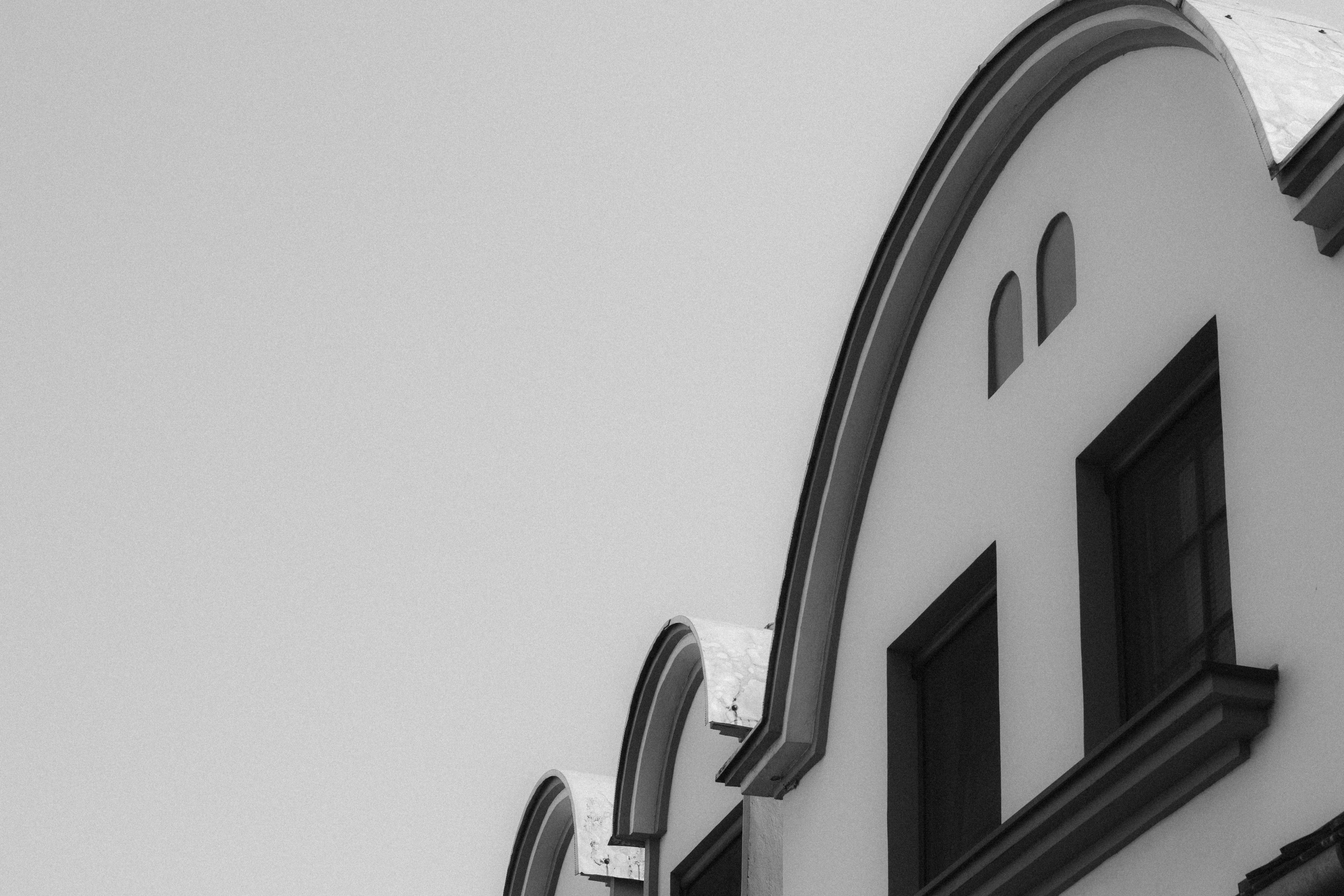 Archway Echoes: A Cornered Facade in Quiet Monochrome