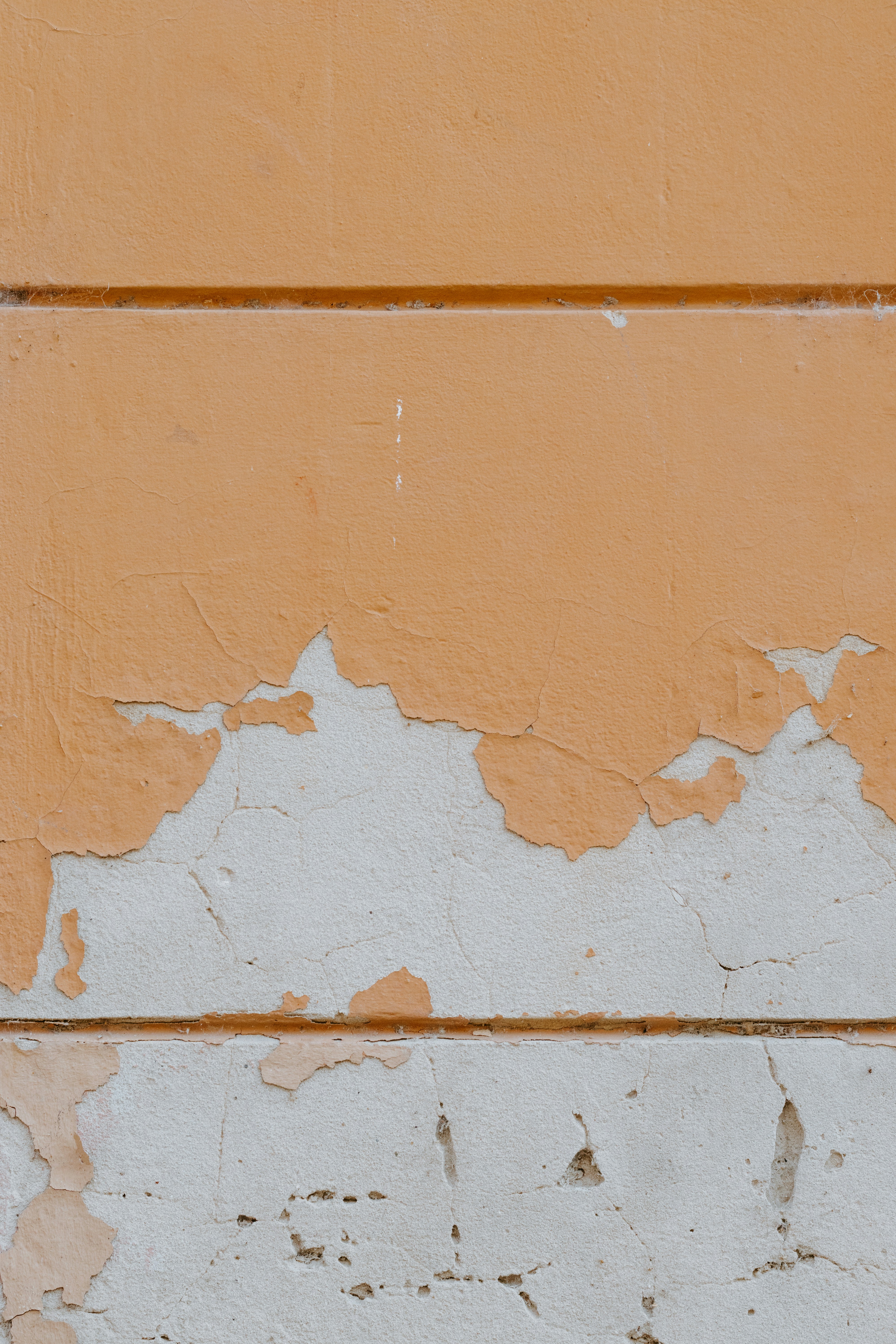 Peeling Paint on Quiet Wall: Earthy Tones Revealing Weathered Layers