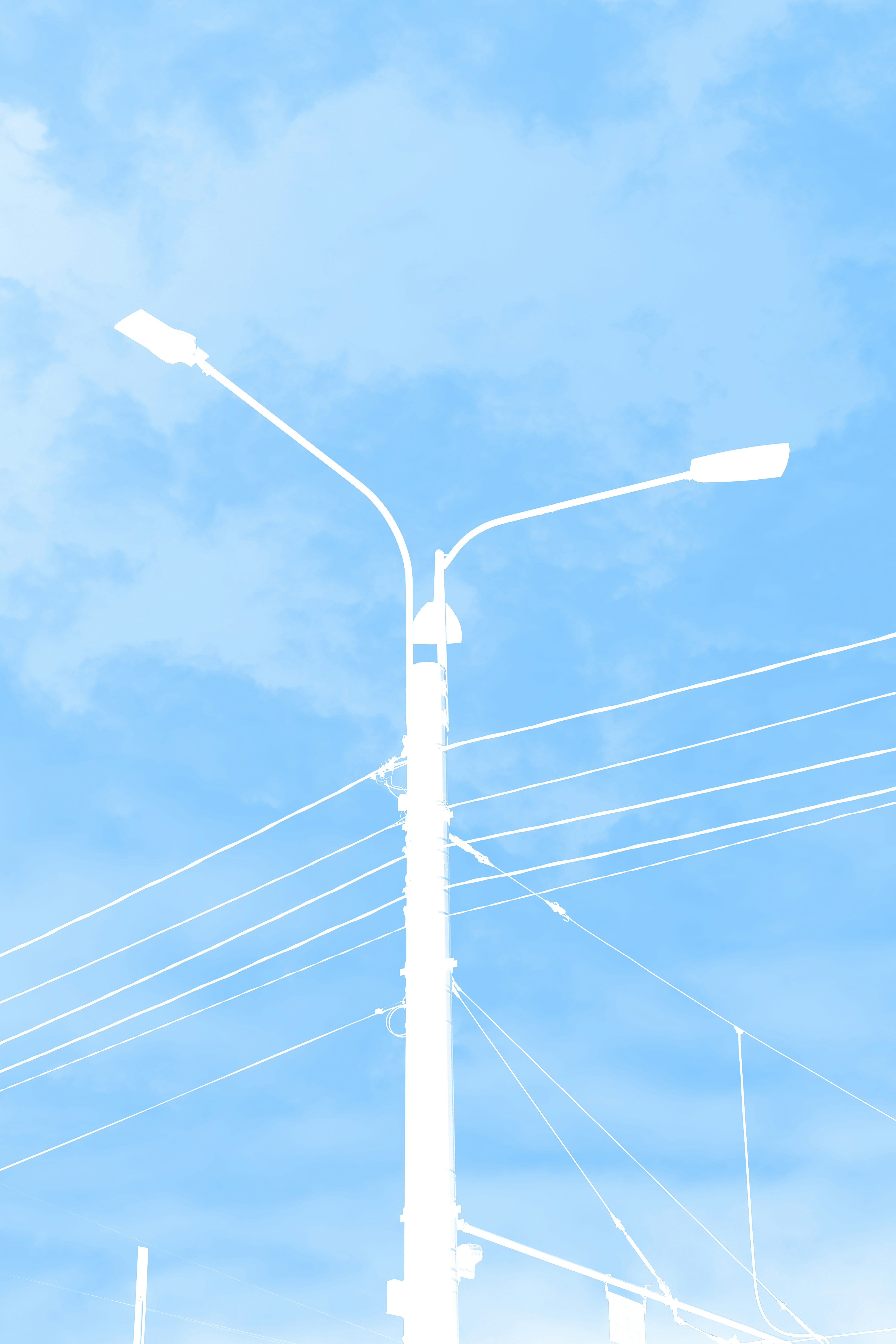 Silhouette of a Streetlight Mast Against a Clear Sky
