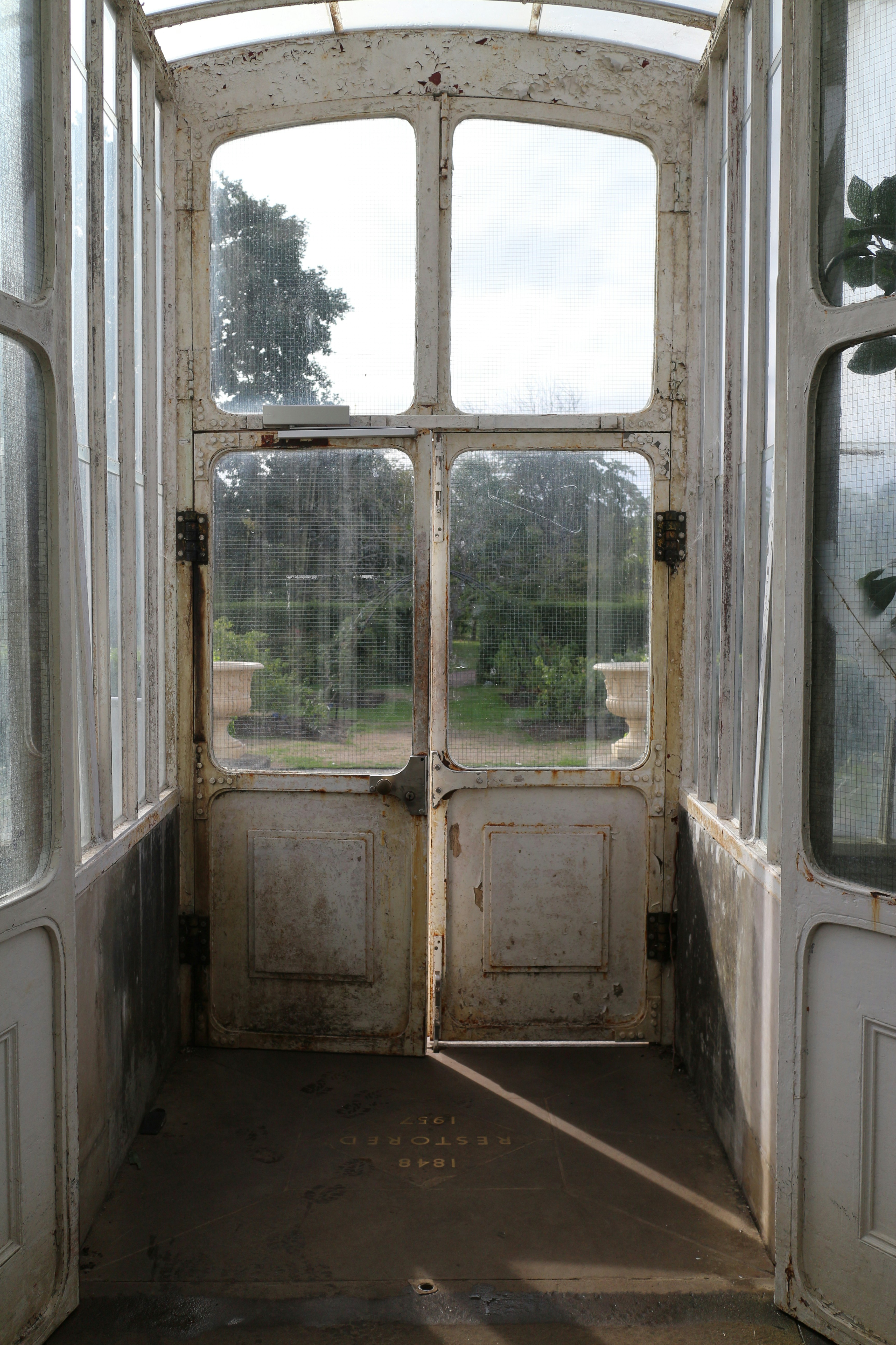 Weathered Conservatory Doorway Framing a Garden Vista
