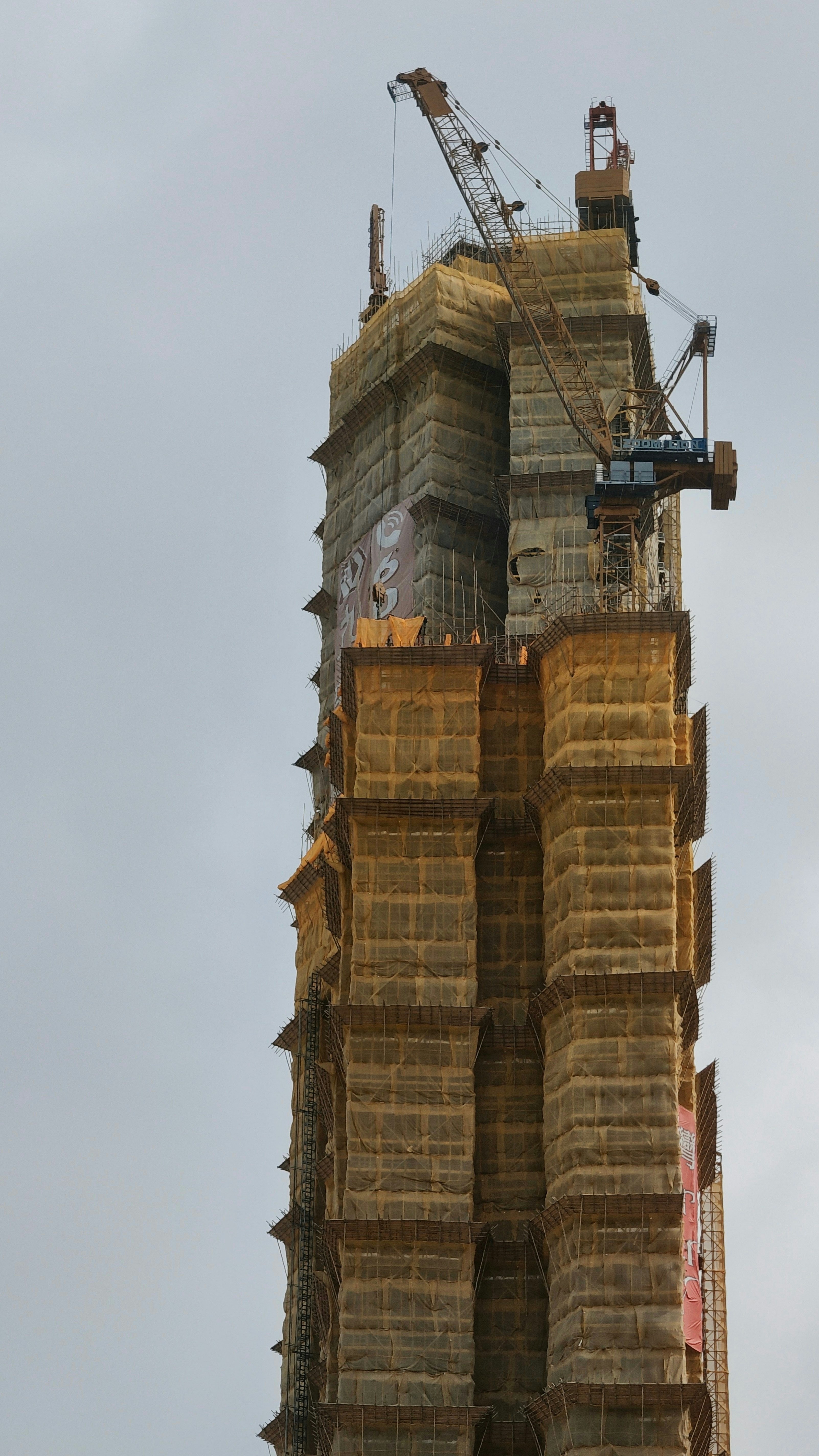 Lancet of Progress: A Crane-Threaded Tower Reaches Skyward