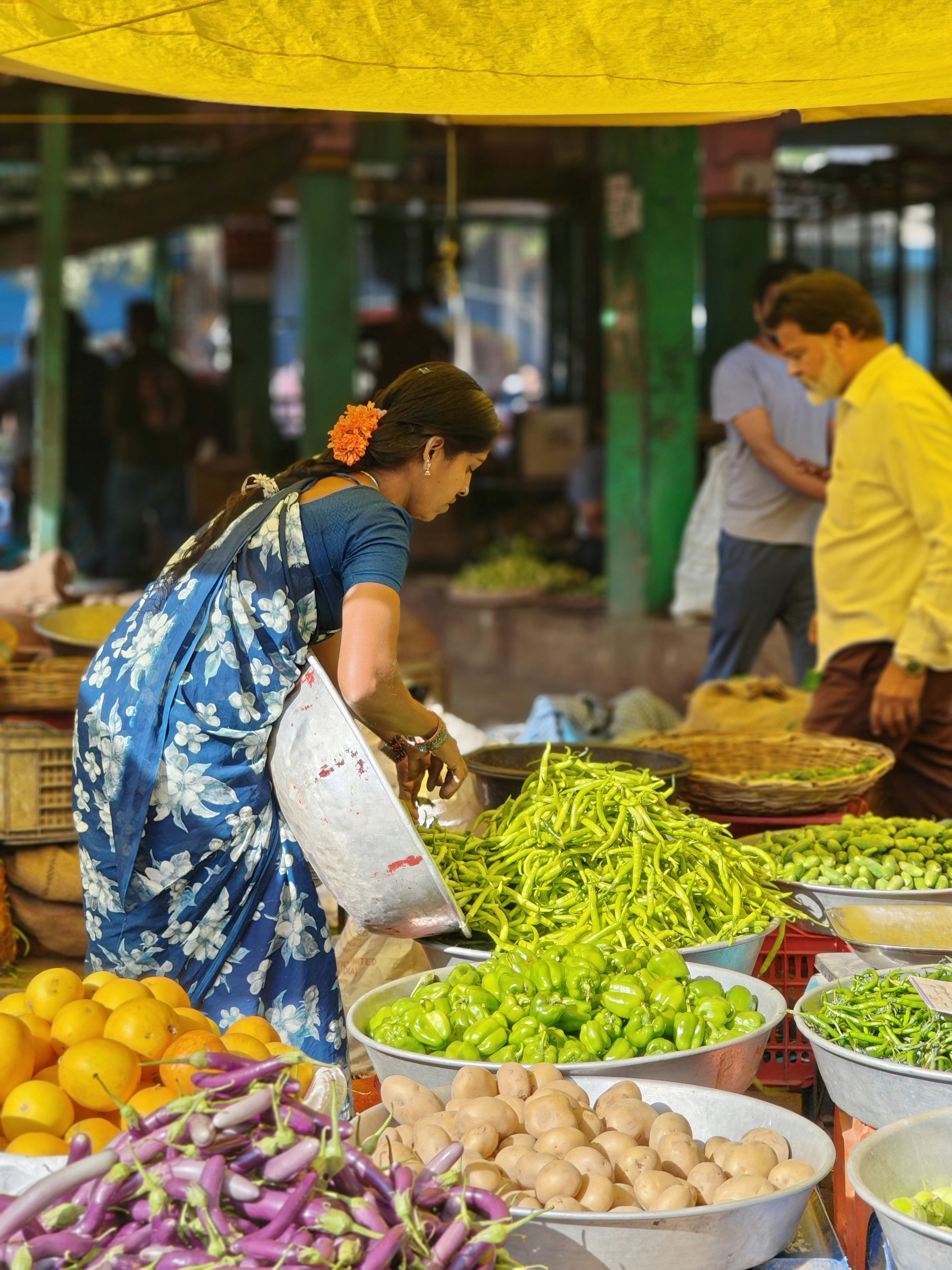 Blue Sari, Orange Flower, and Fresh Produce at a Bustling Market Bench