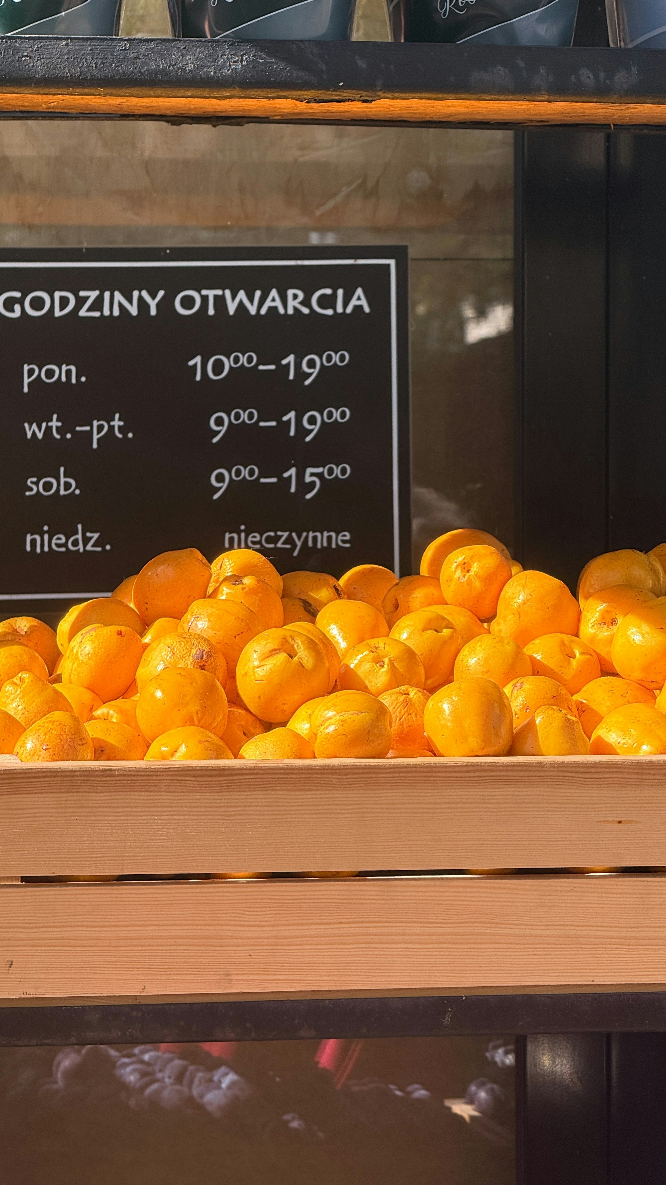 Bright Bunch: Tangerine Oranges Framed by a Market Sign