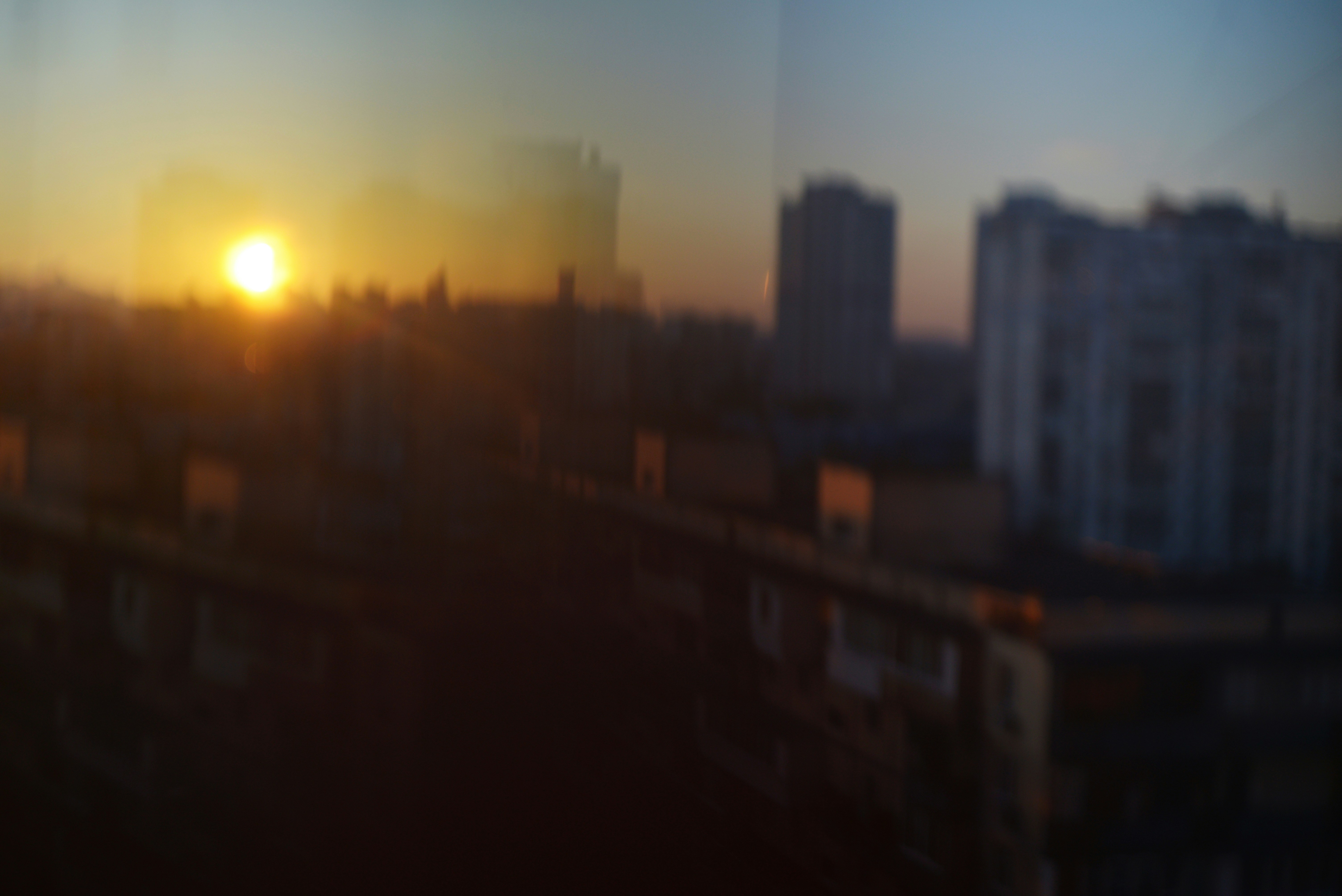 Sunset over a Blurred City: Warm Glow on Glass