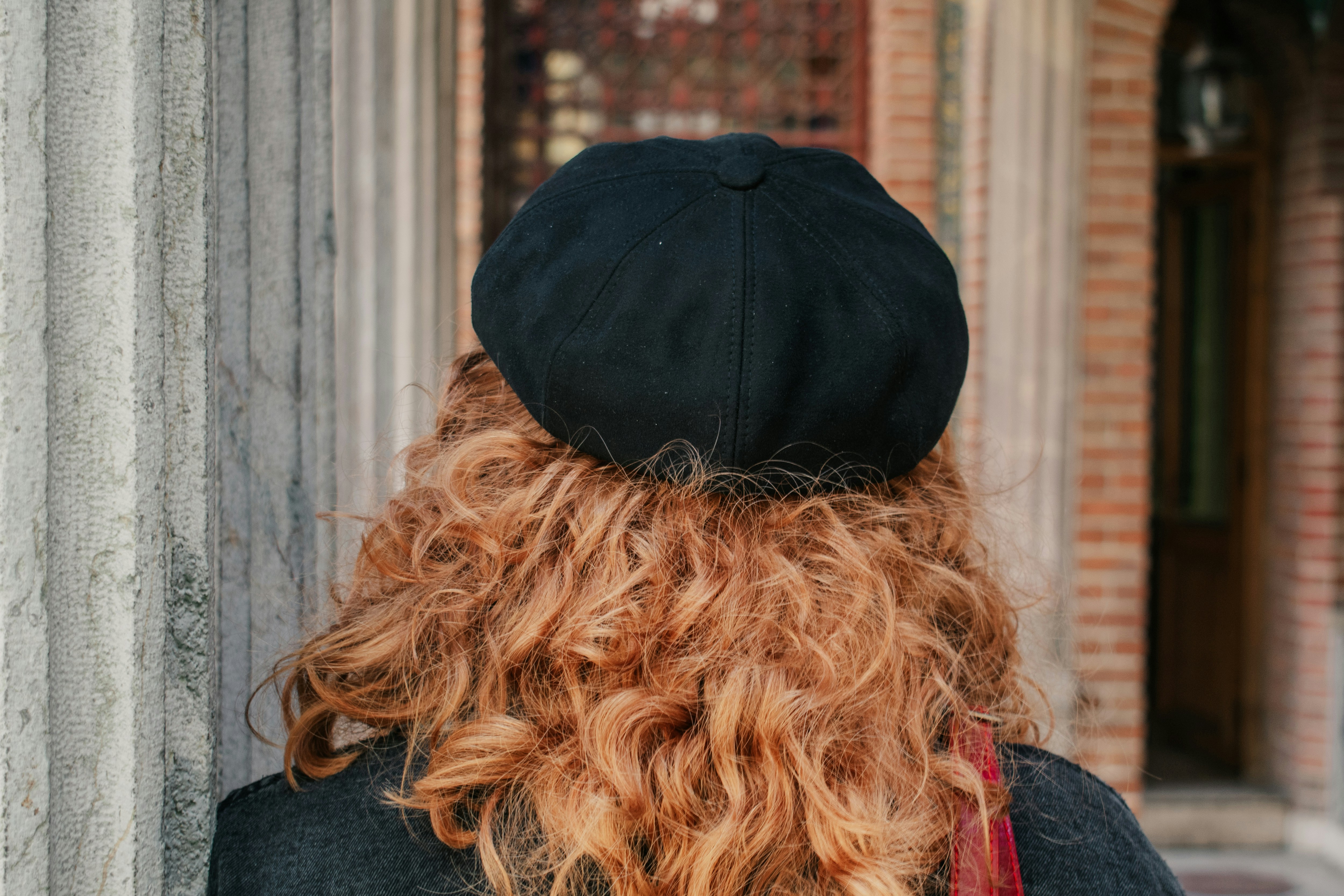 Curled Copper Waves Under a Black Cap