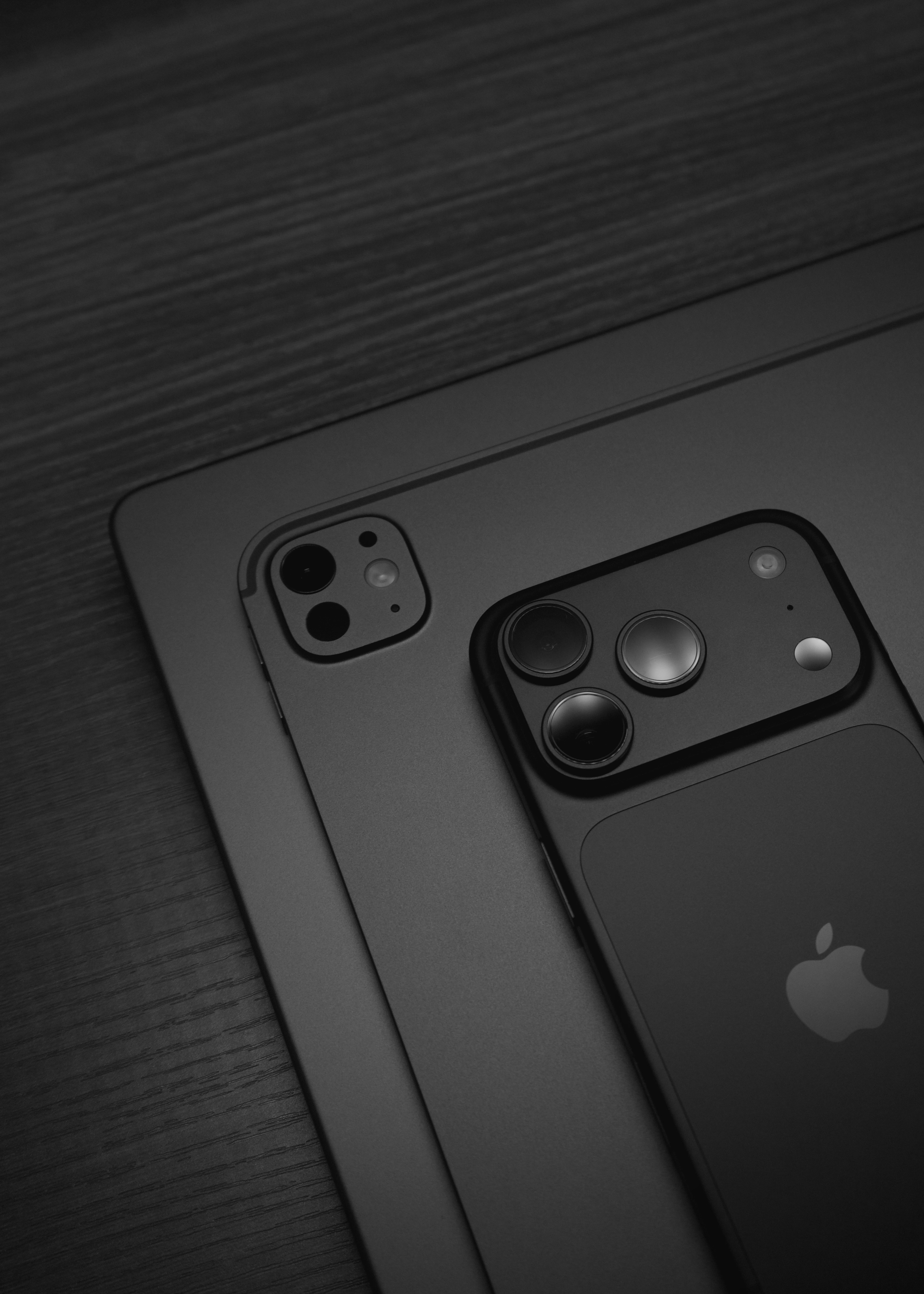 Dual-Lens Tech: A Matte Black Moment of iPhone and iPad Nestled on Wood