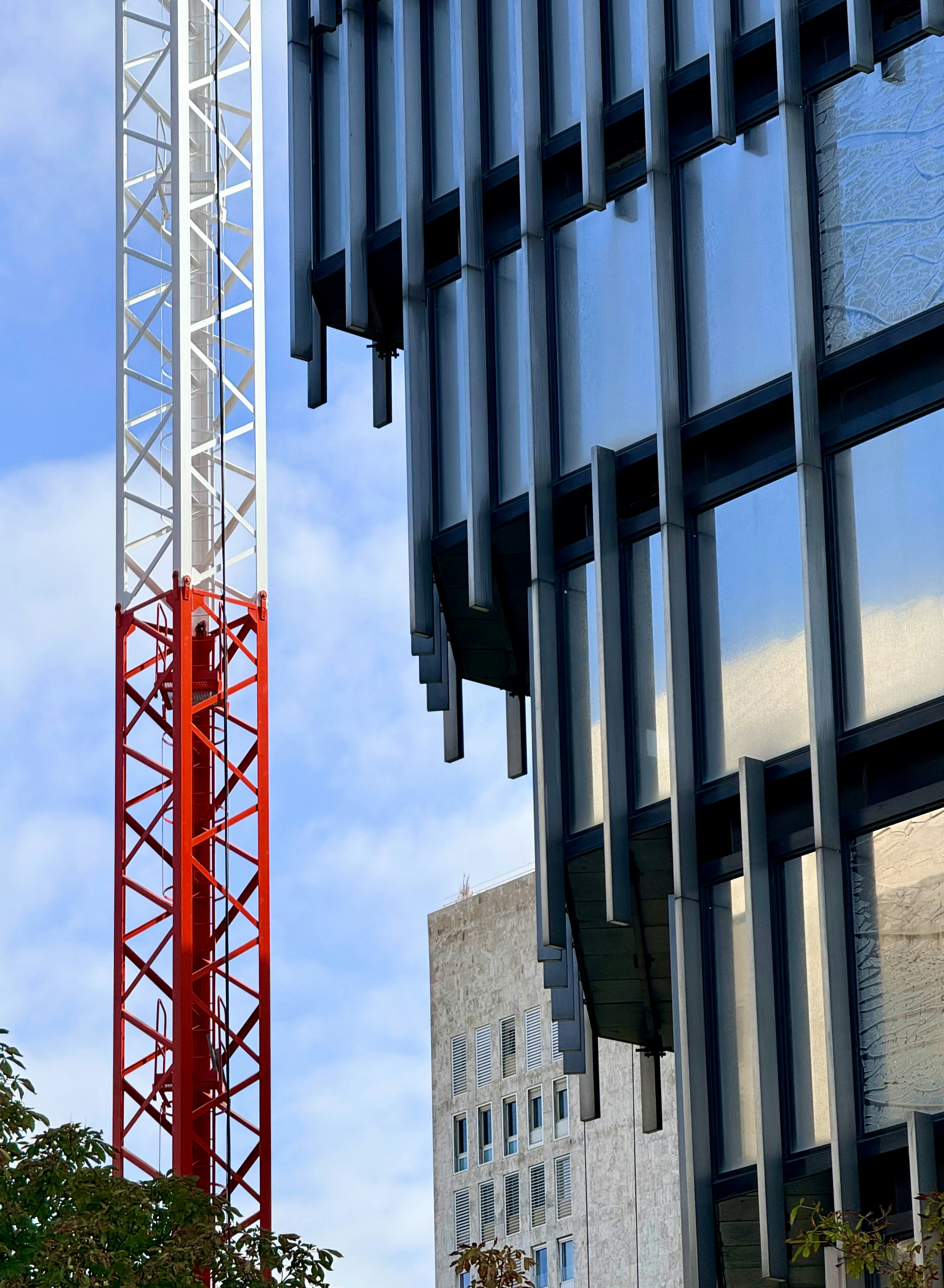 Crisscross Tower Slices Against Modern Glass Facade