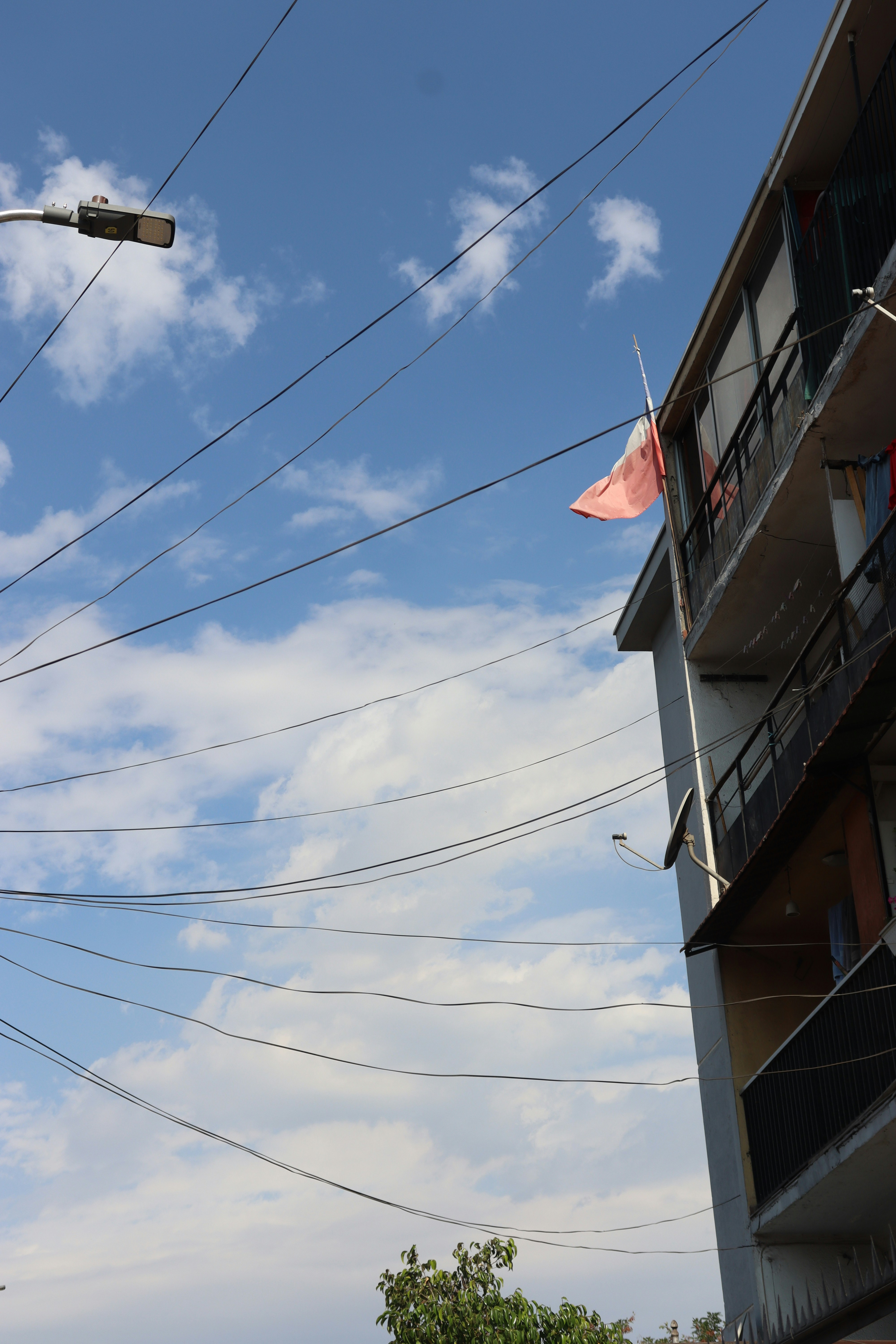 Lines Across the Sky: A Balcony of Wires and Clouded Light