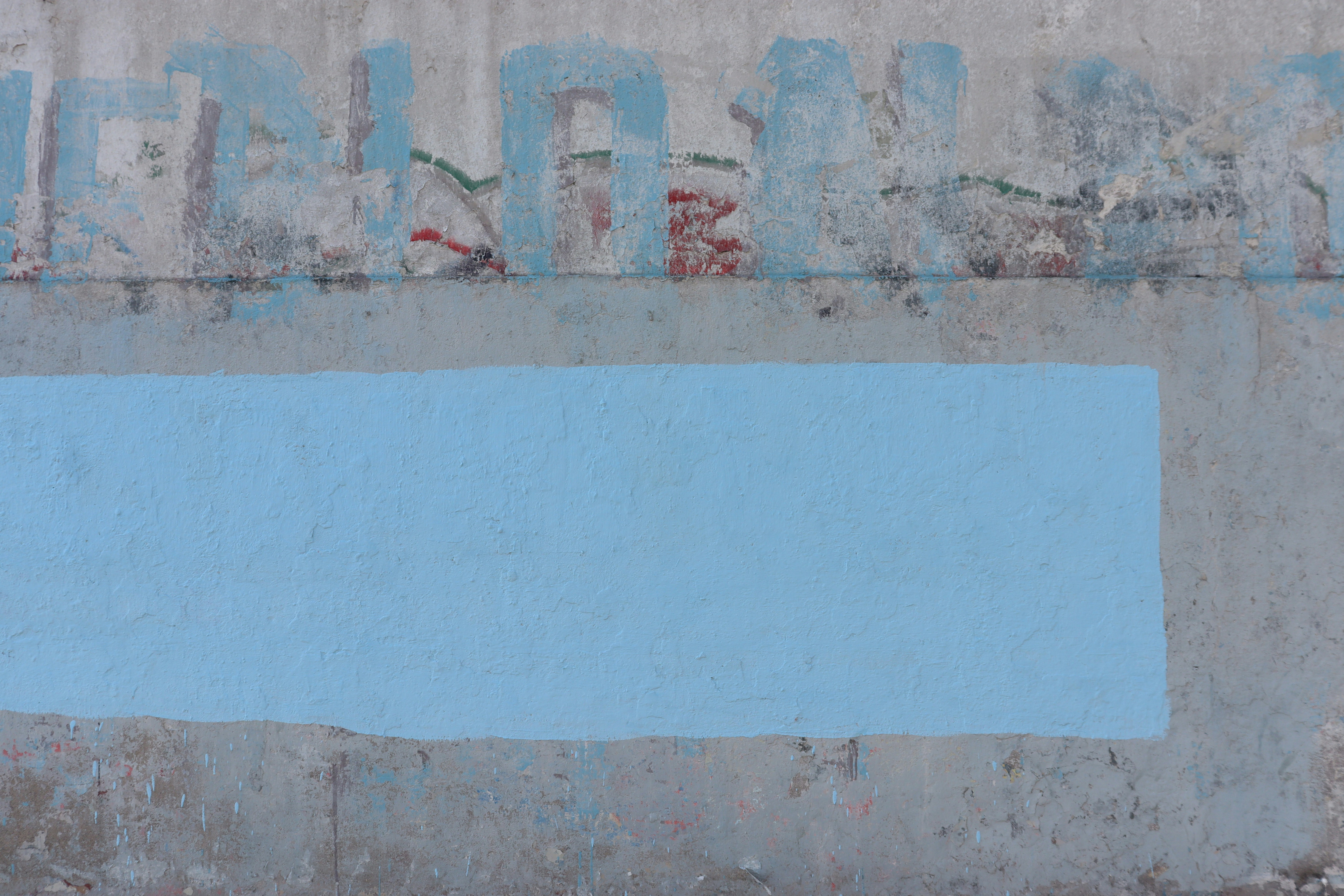 Blue Rectangle on Weathered Concrete Wall