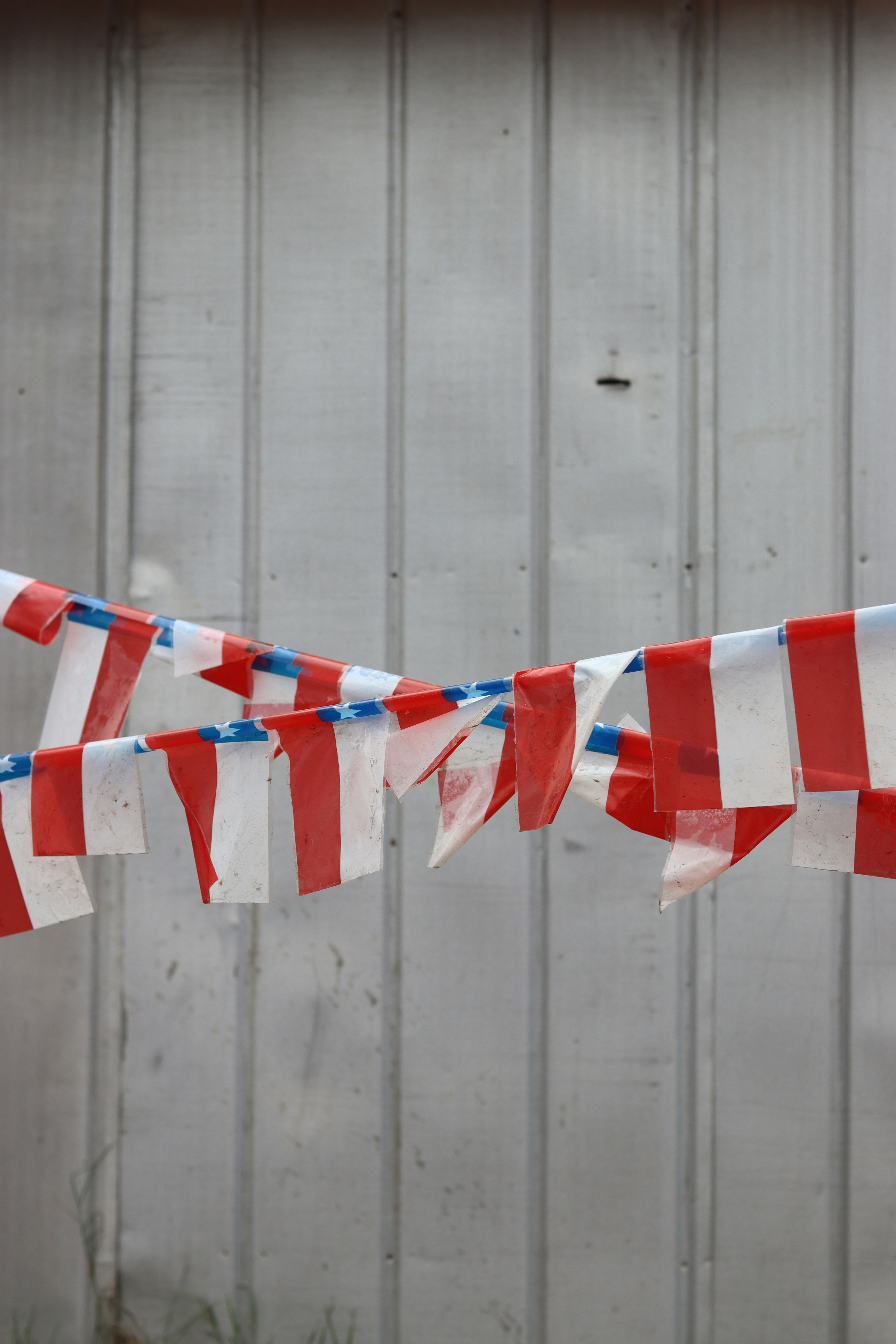 Suspended Signal: Red and White Flags Across a Quiet Industrial Wall