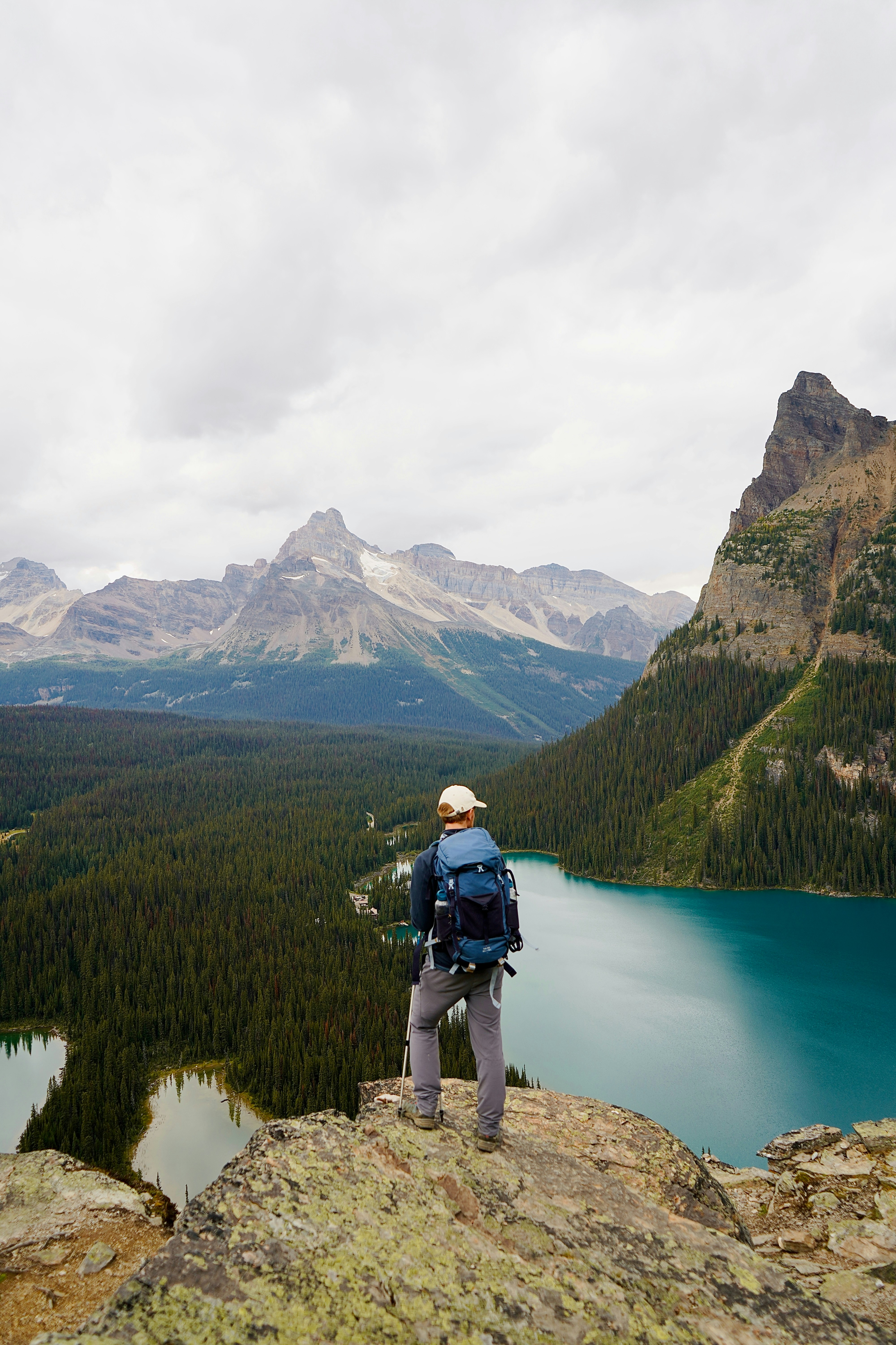 Hiker on the Edge: A Quiet Summit Over Turquoise Alpine Waters