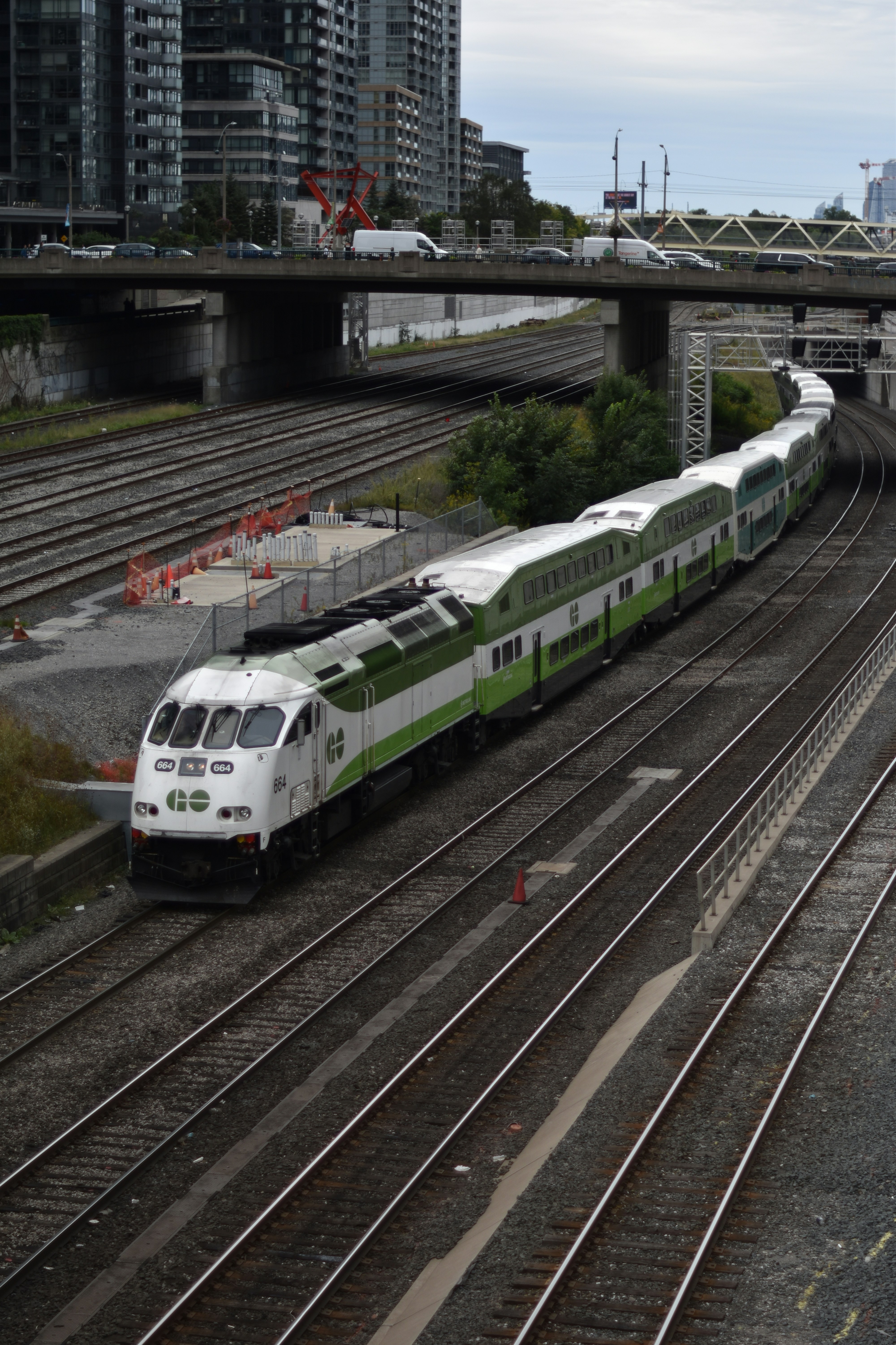 Green-Stripe Rail Marvel: A commuter train Winds Through Urban Rails