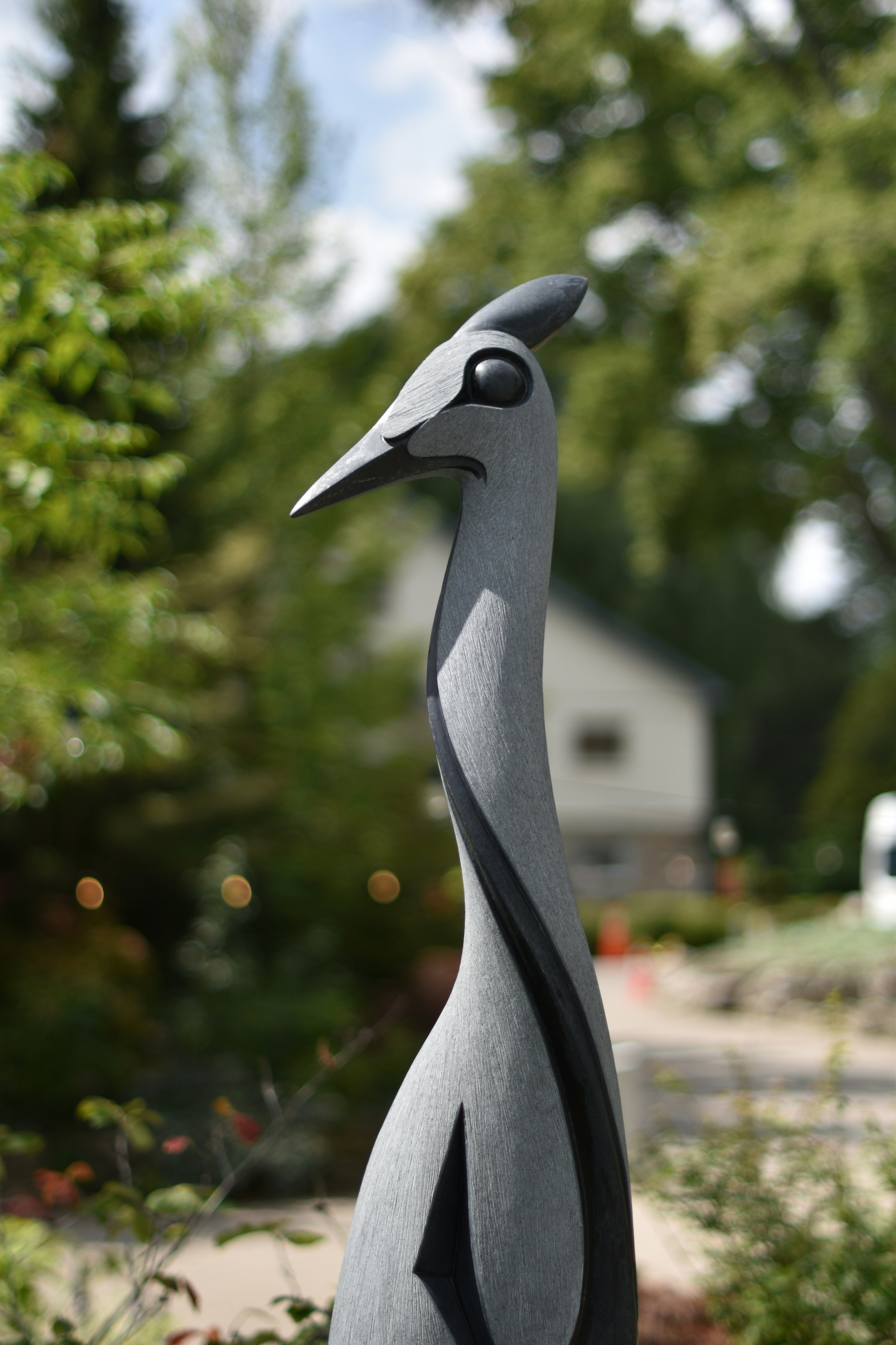 Stone Crane: A Quiet Monolith Against a Garden Backdrop