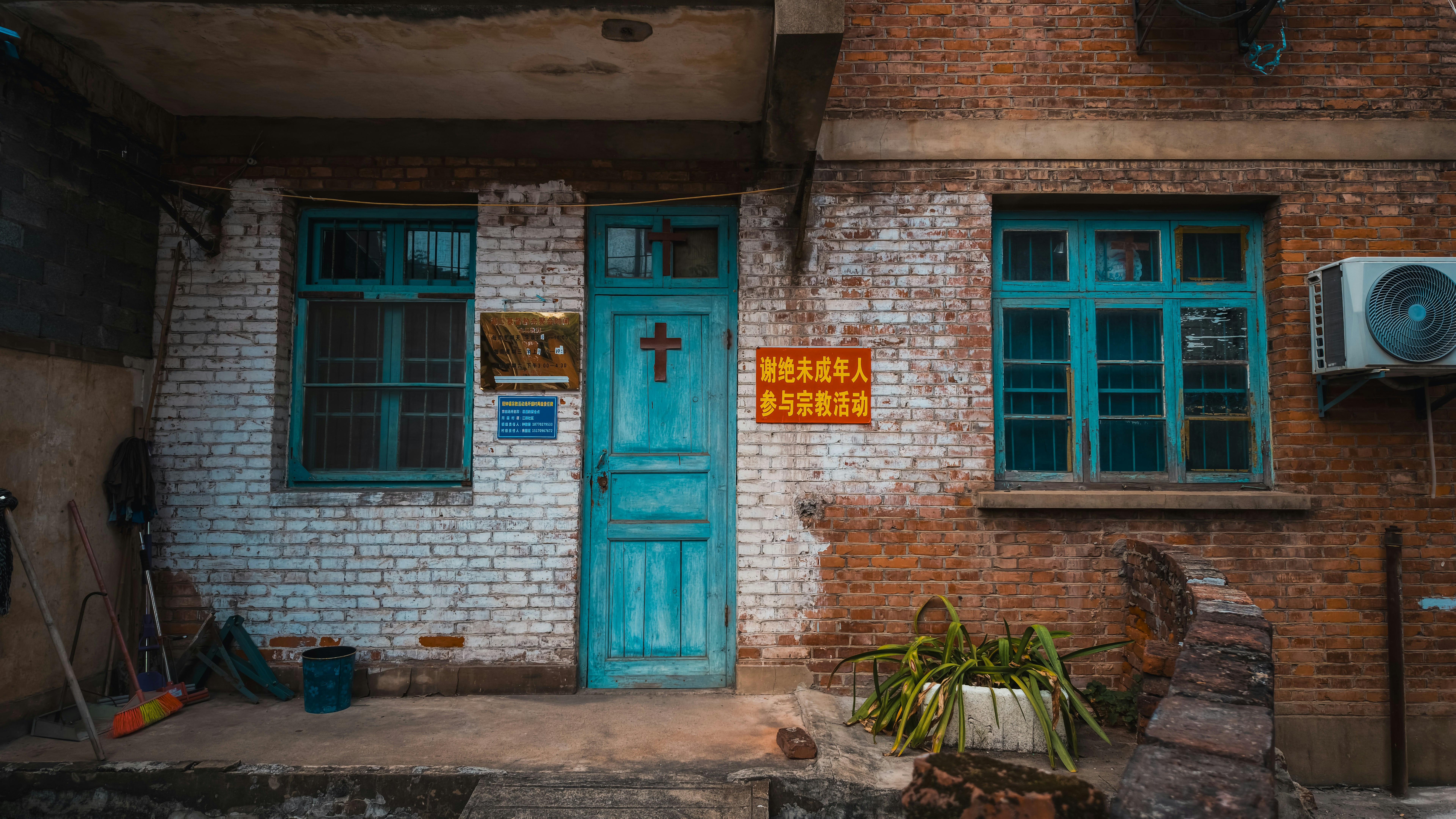 Blue door with crossboard: a quiet courtyard of bricks and signs