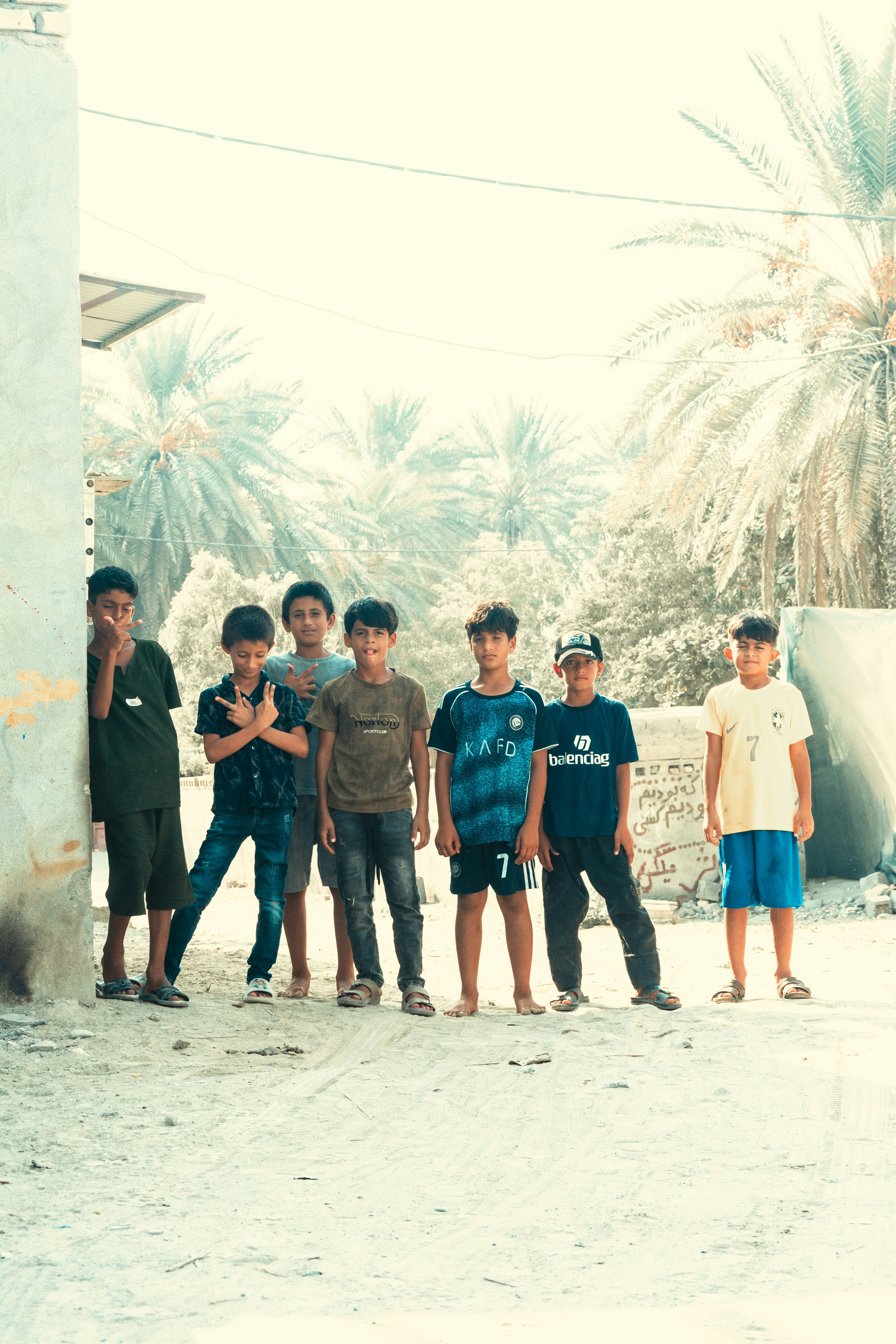 Group of Village Kids Posed in Dusty Alley with Palm Trees