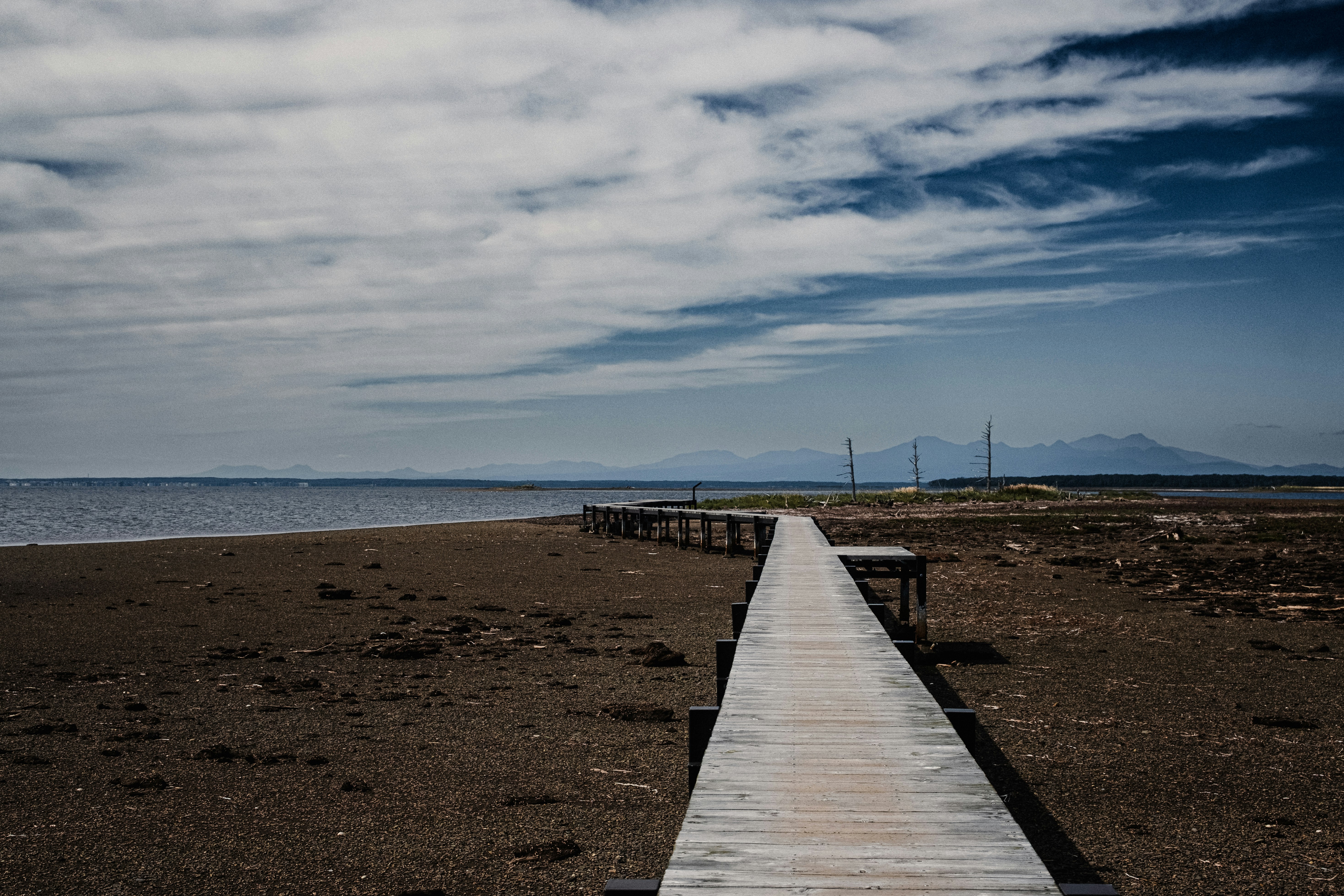 Pier to the Horizon: A Wooden Walkway Reaching the Sea