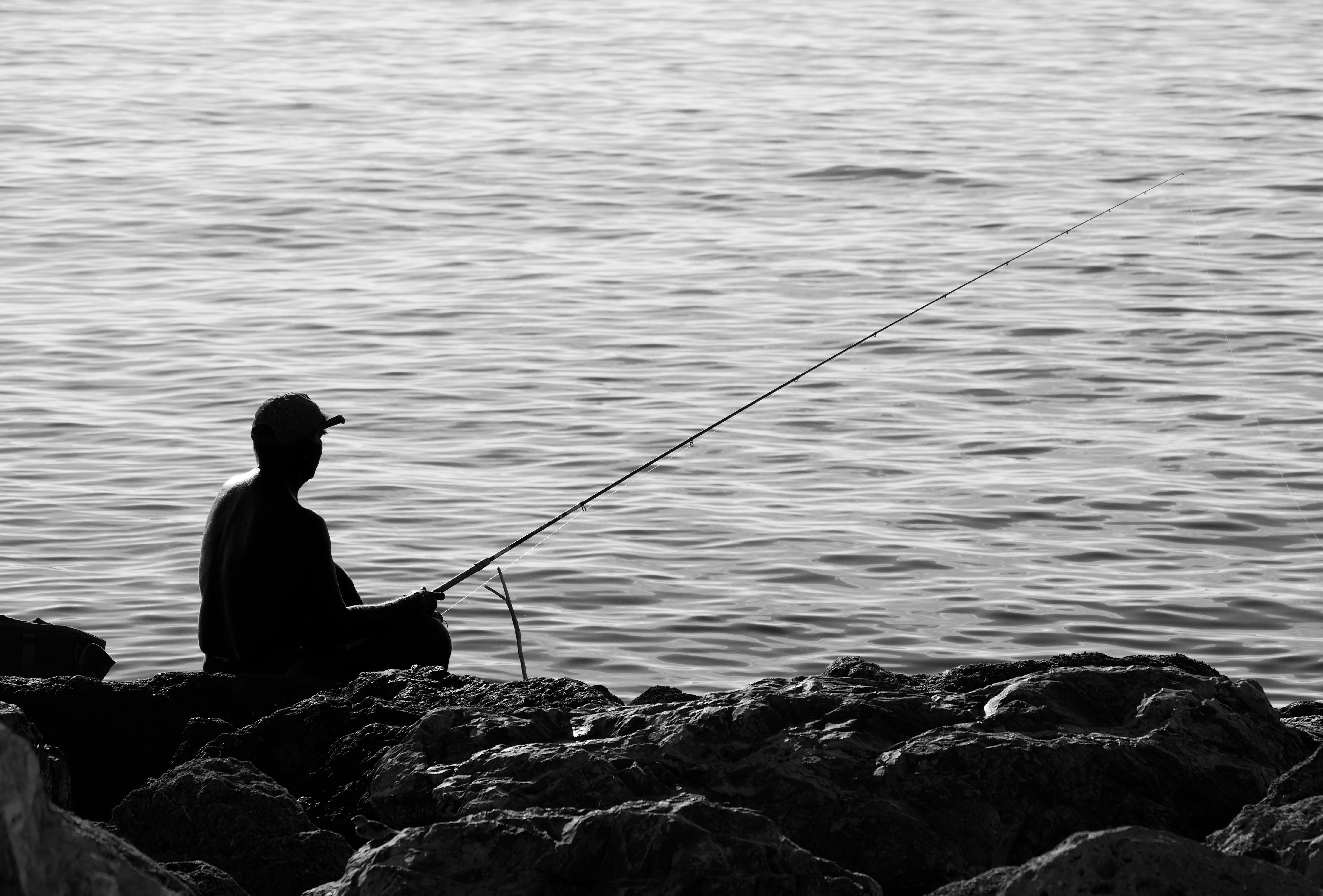 Silhouette at the Breakwater: Quiet Casting by the Shore