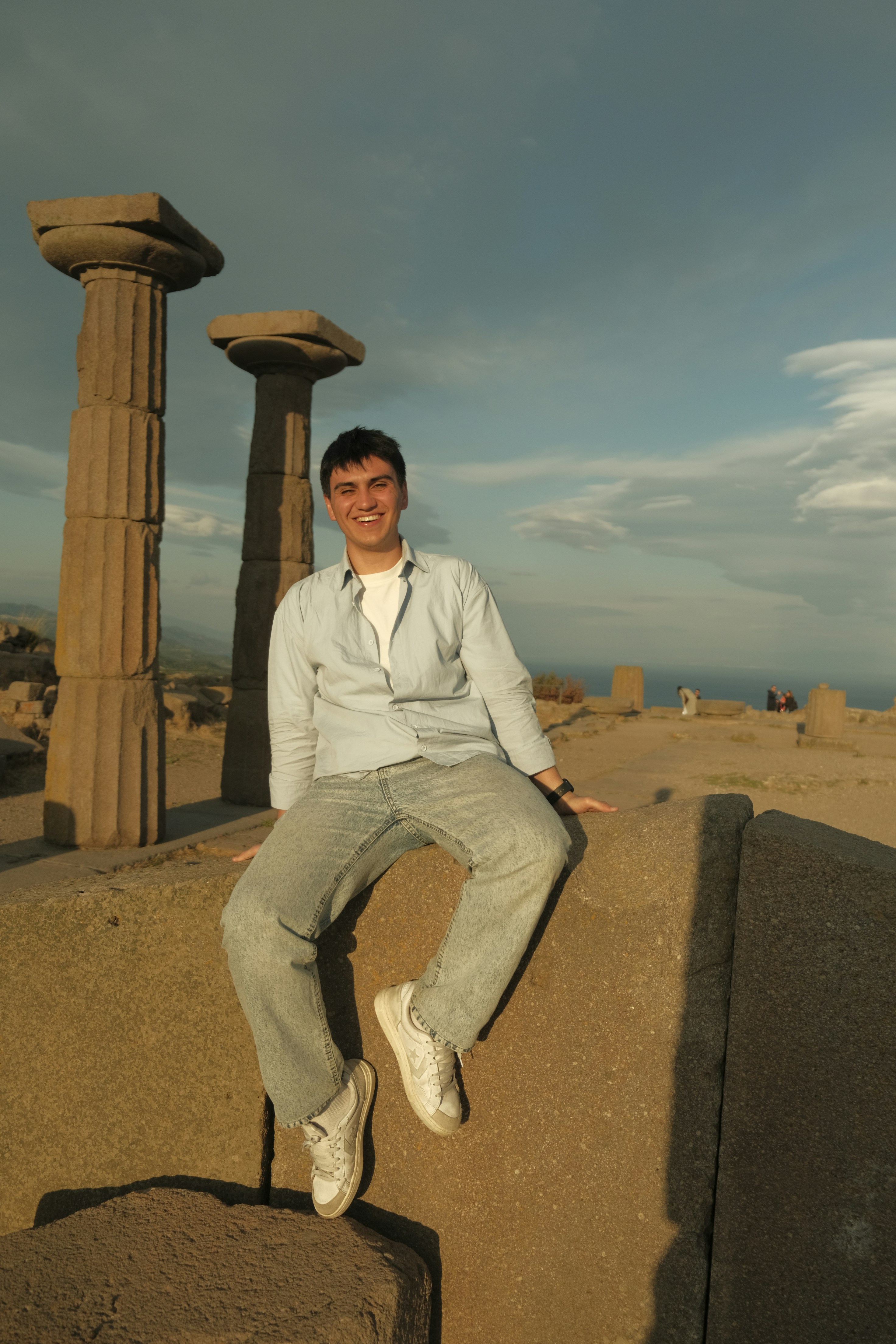 Sunlit ruins and a cautious smile on a cliffside promenade