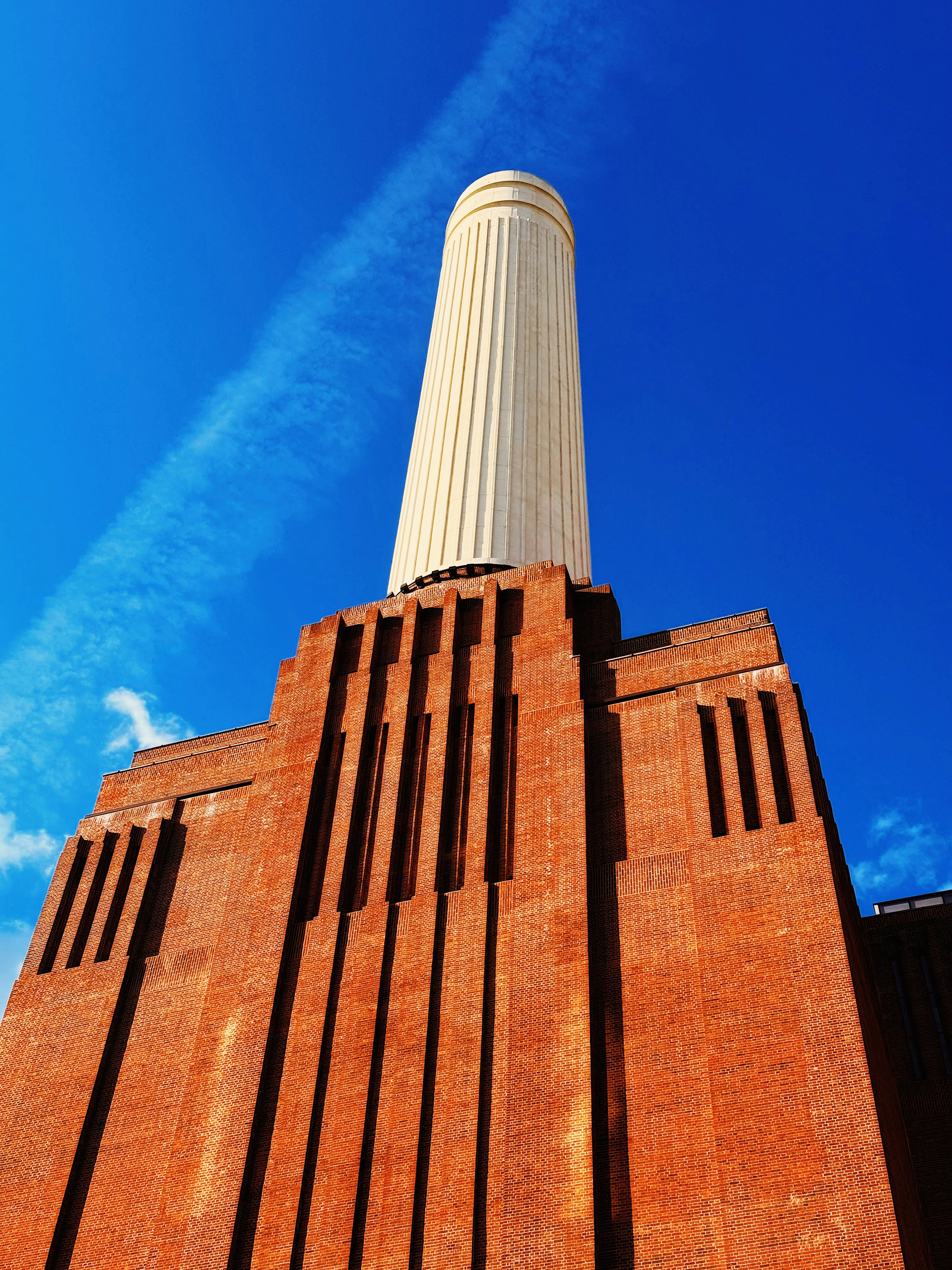 Brick towers and a gleaming column crowned in blue