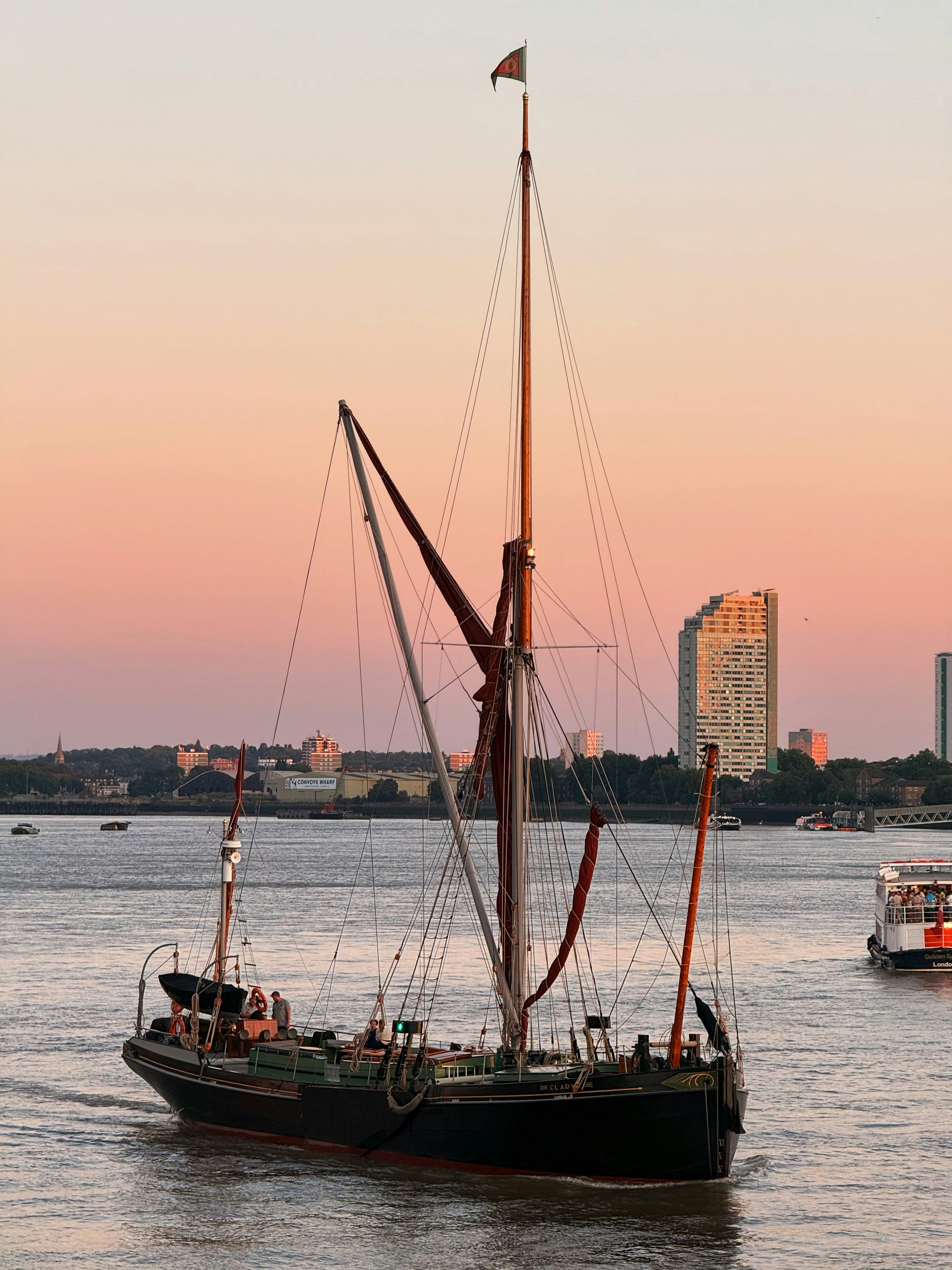 Sailing at Dusk: A Lone Schooner Conquering the River