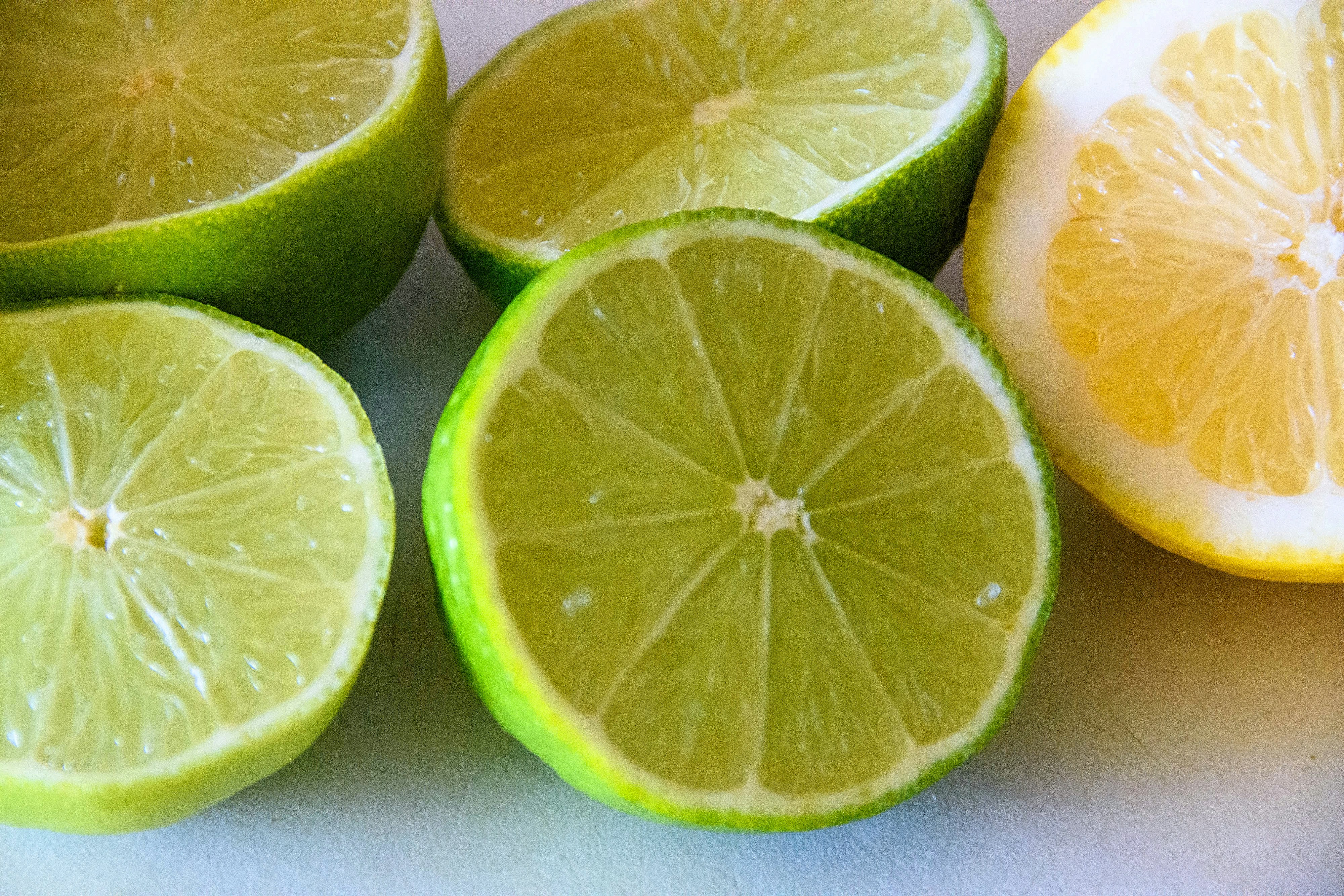 Citrus Confluence: Limes and a Lemon Framing a Fresh Slice