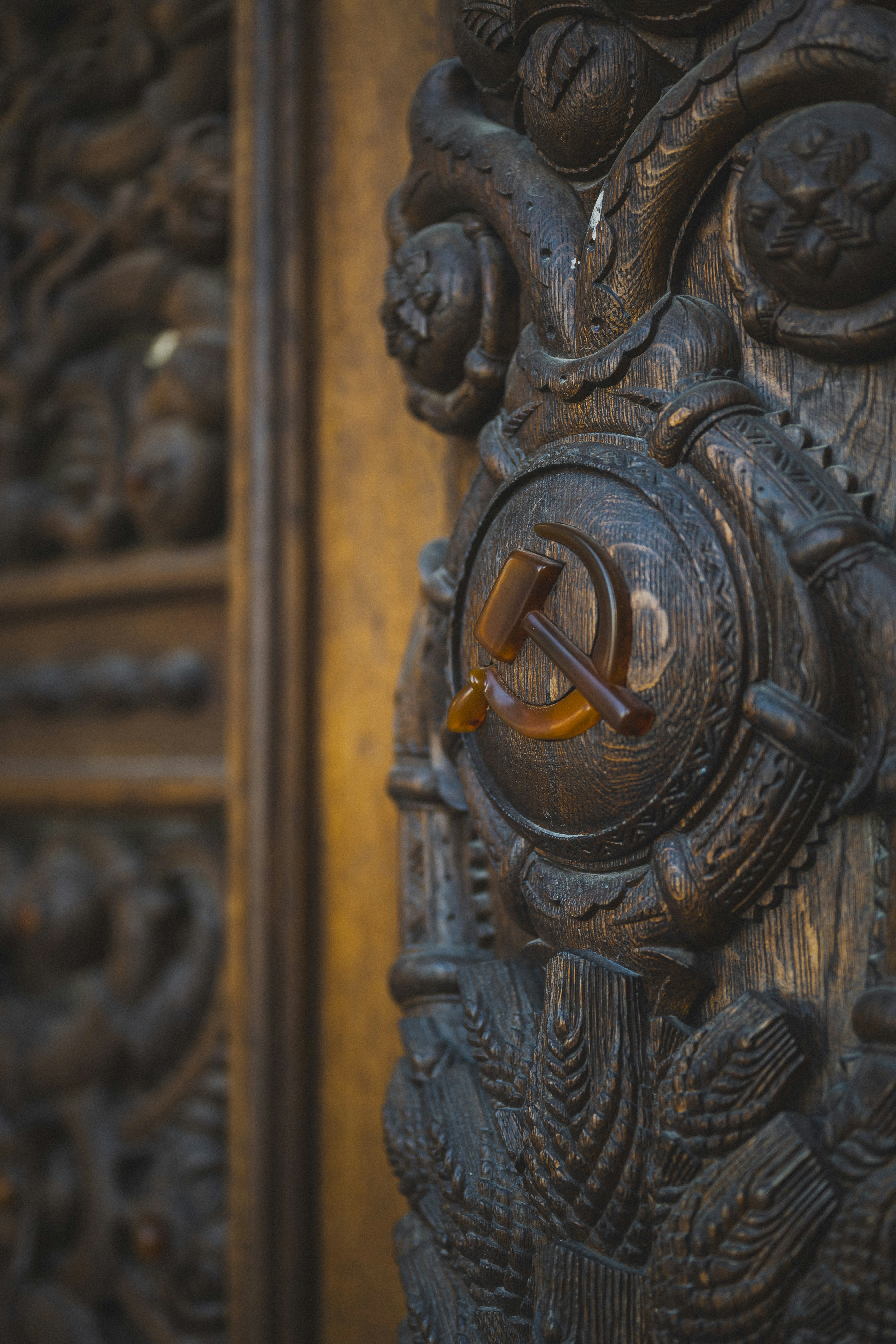 Carved Door Knocker on Aged Timber: An Intricate Mechanism of Texture and Time