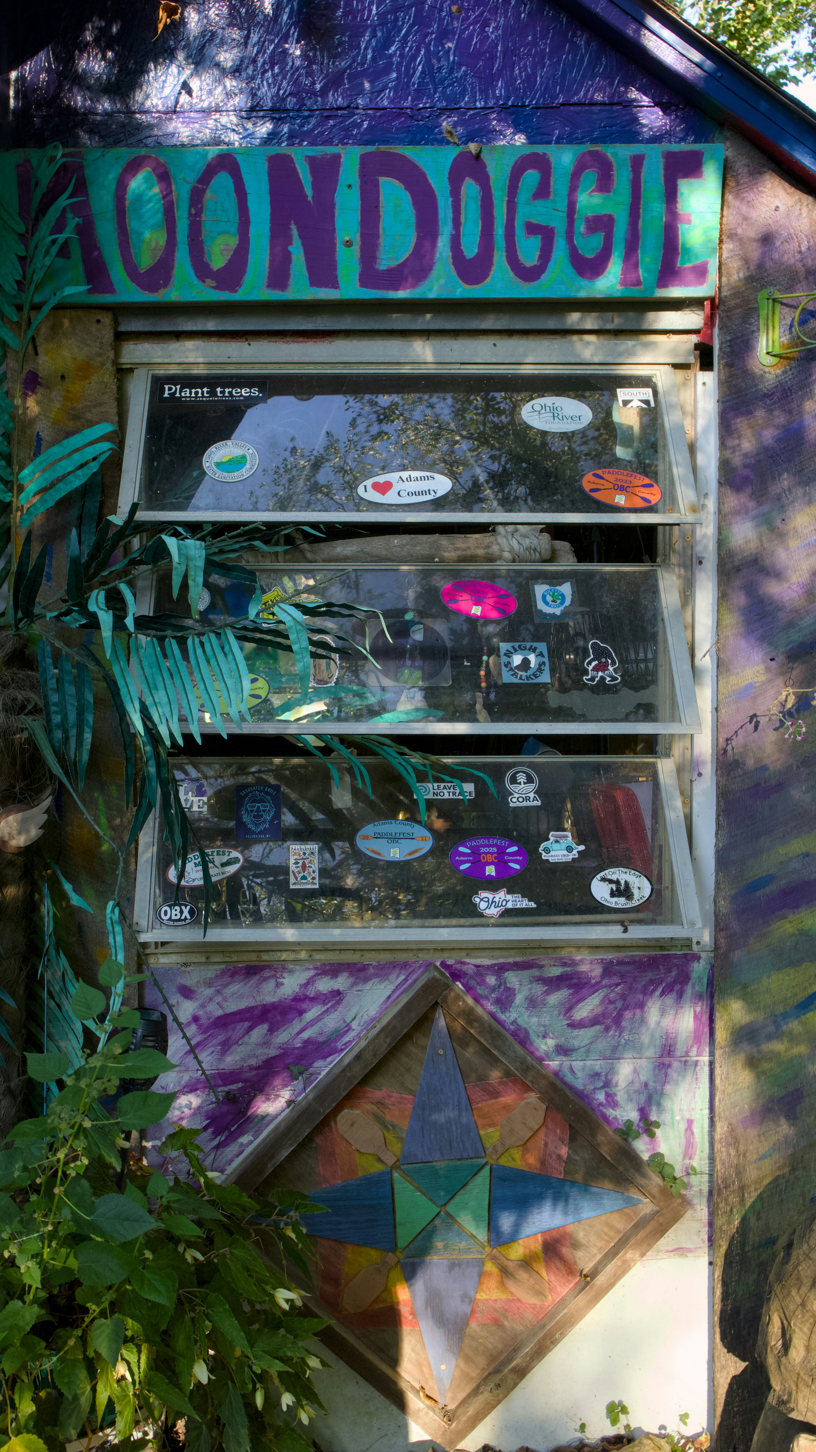 Colorful Alley Shrine: A Soaked Window of Stickers and Sunlit Graffiti