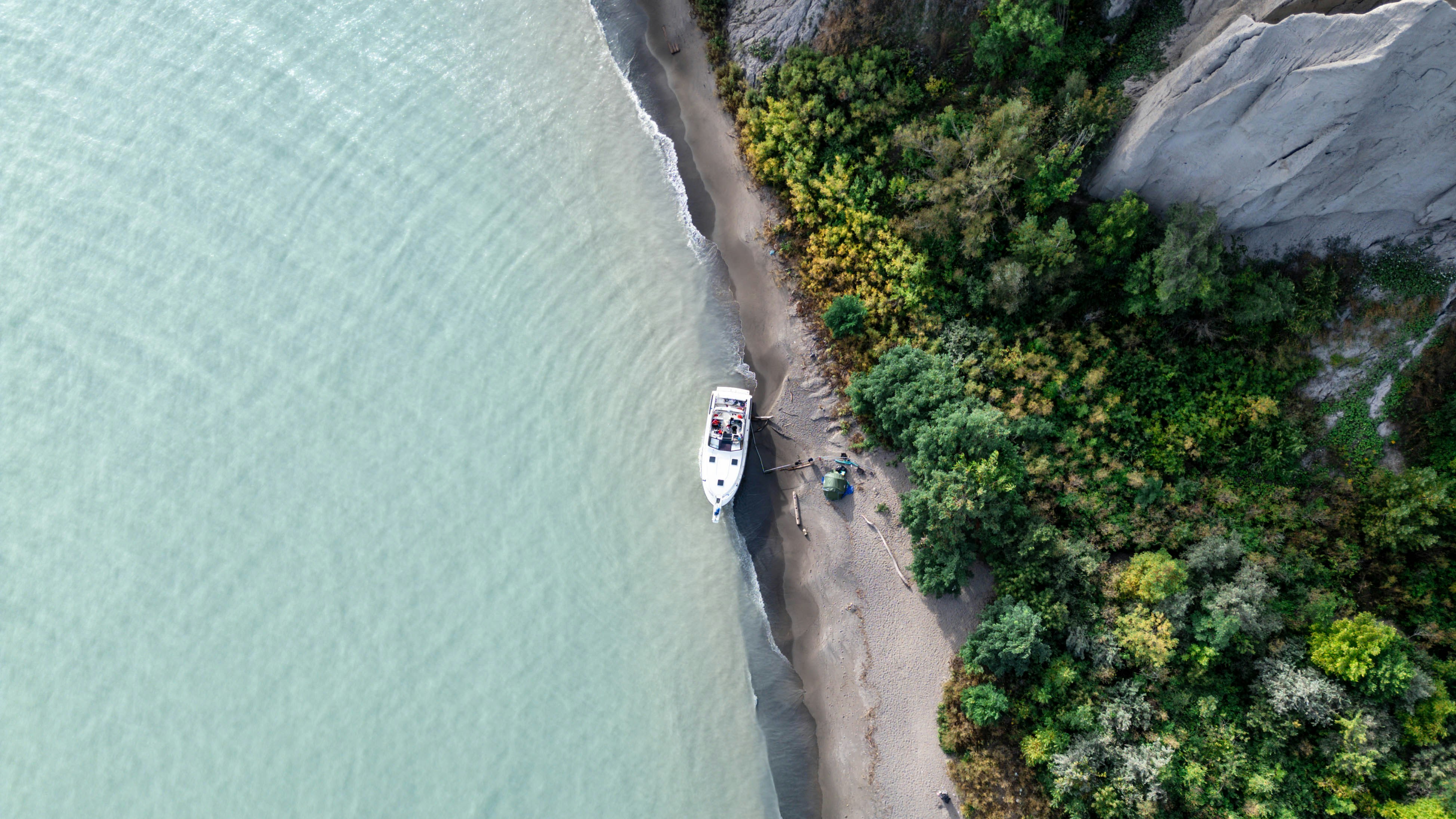 Boat Resting at the Edge: Aerial Moment Over Turquoise Shore