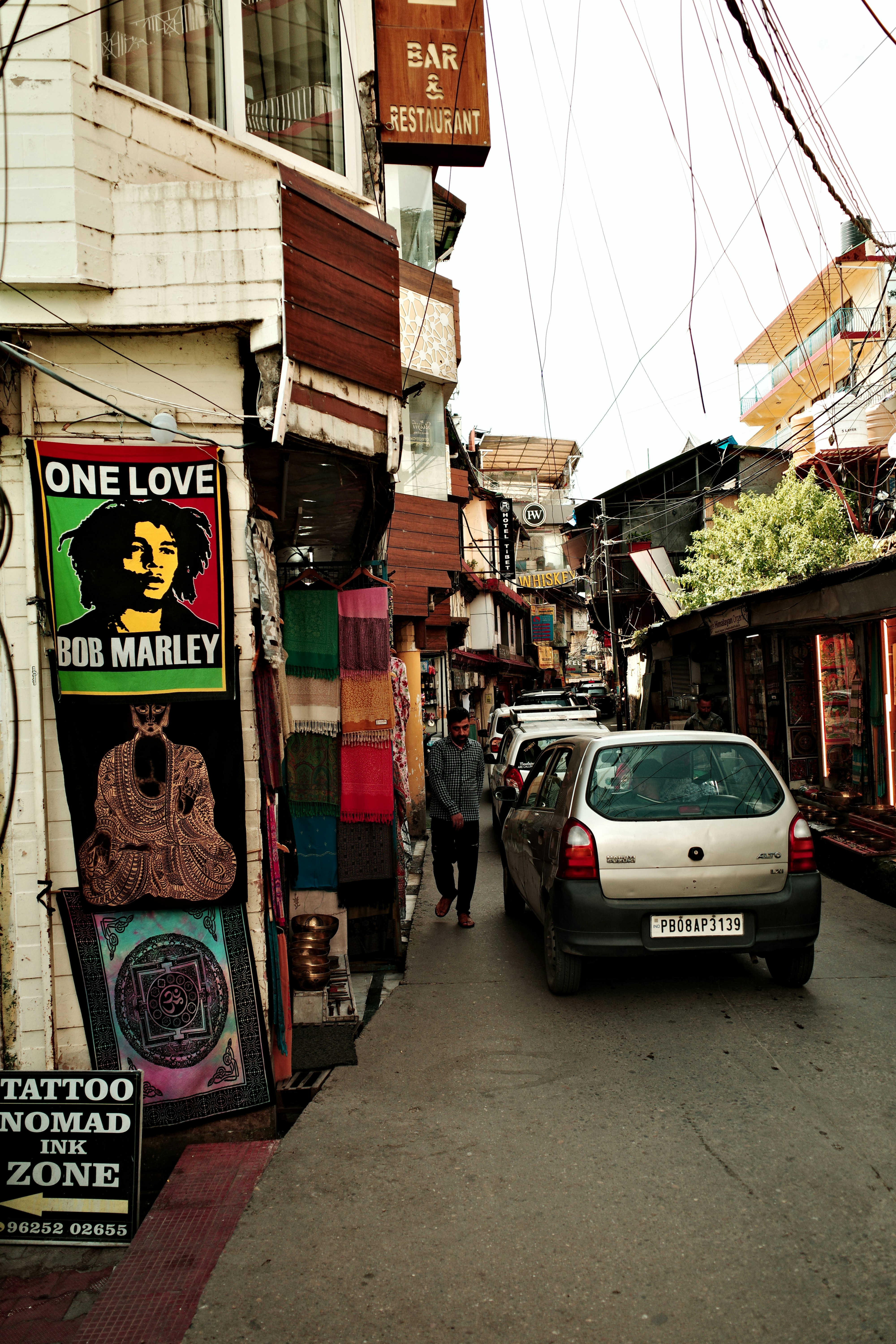 Narrow Bazaar Alleyway with Bob Marley Poster and Passersby