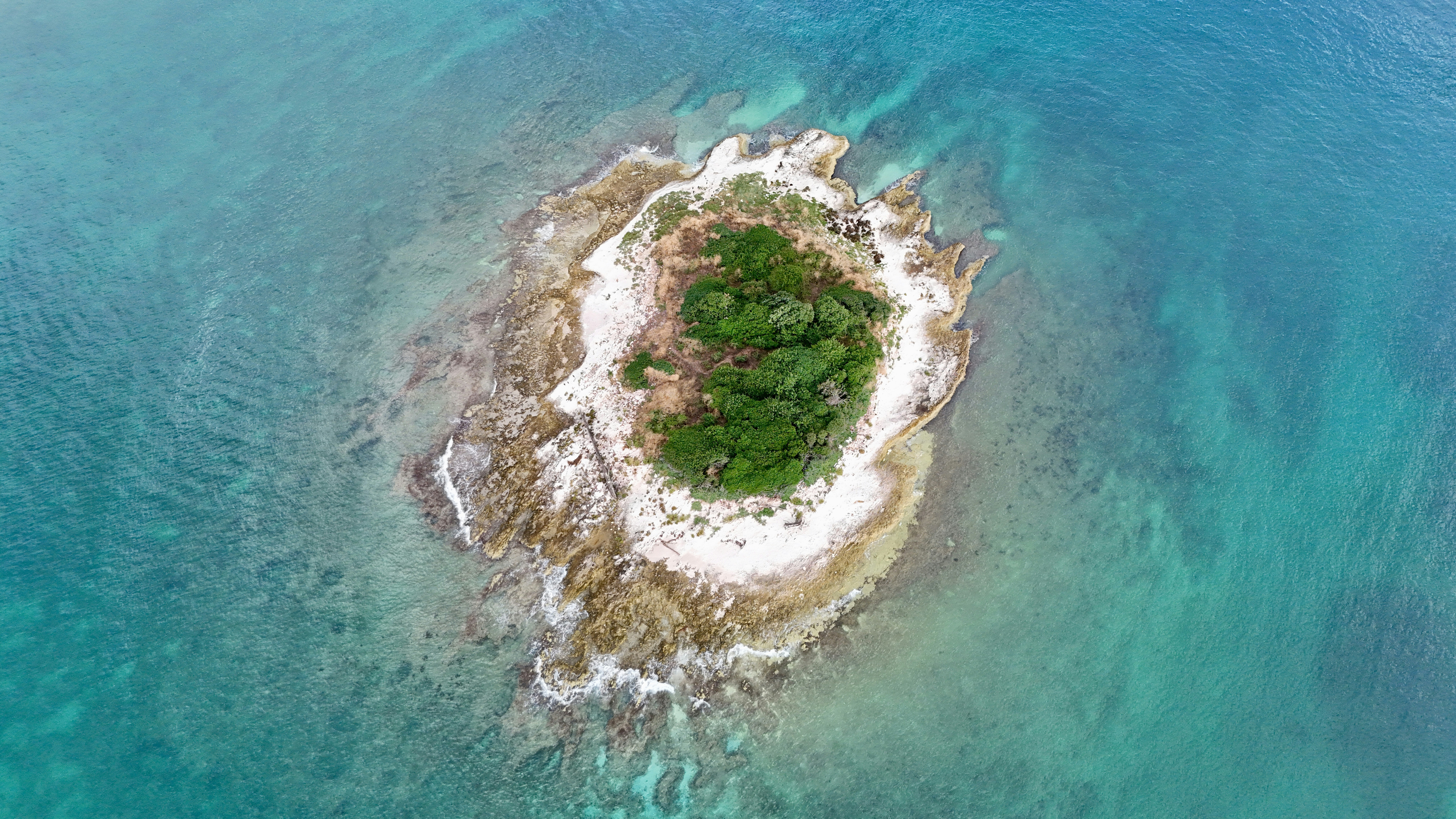 Isolated Green Heart: A Pebble Island in Turquoise Waters