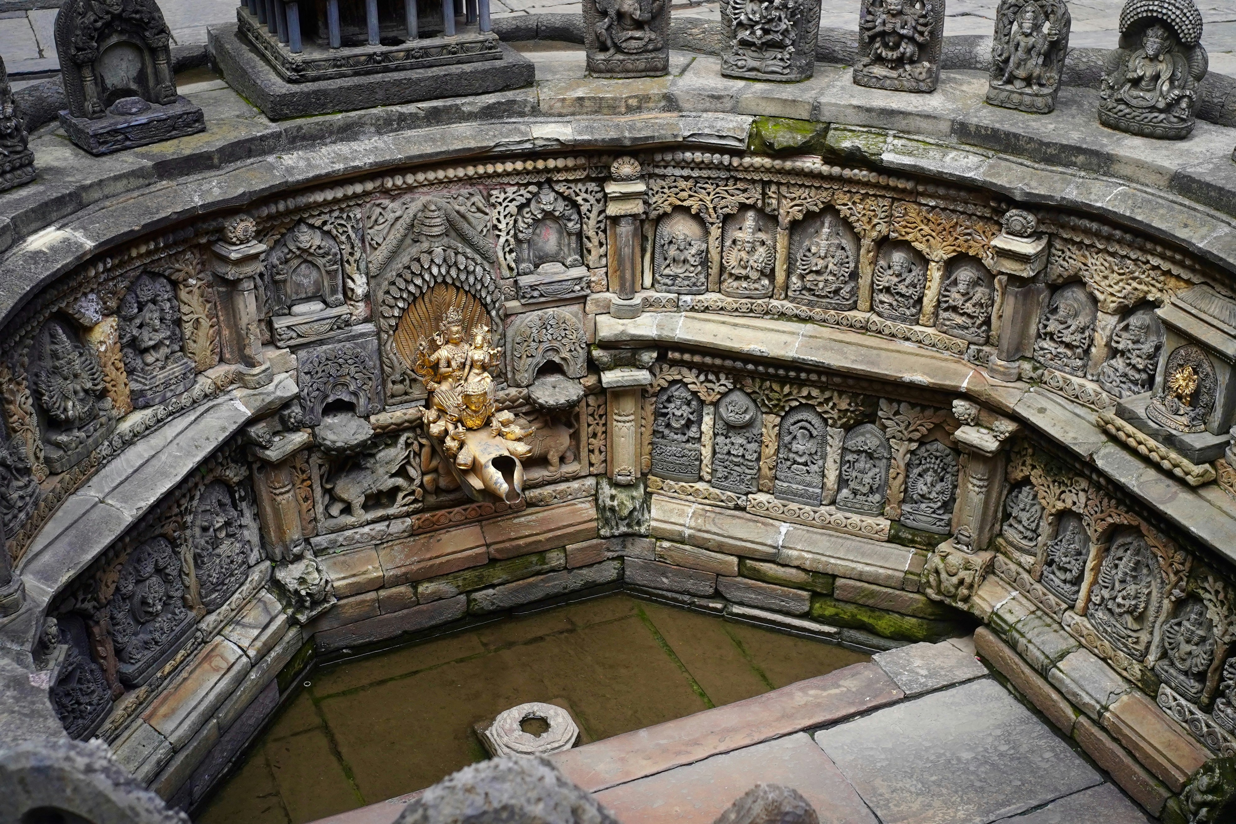 Ancient Circular Niche: Carved Reliefs Encircling a Sacred Pool