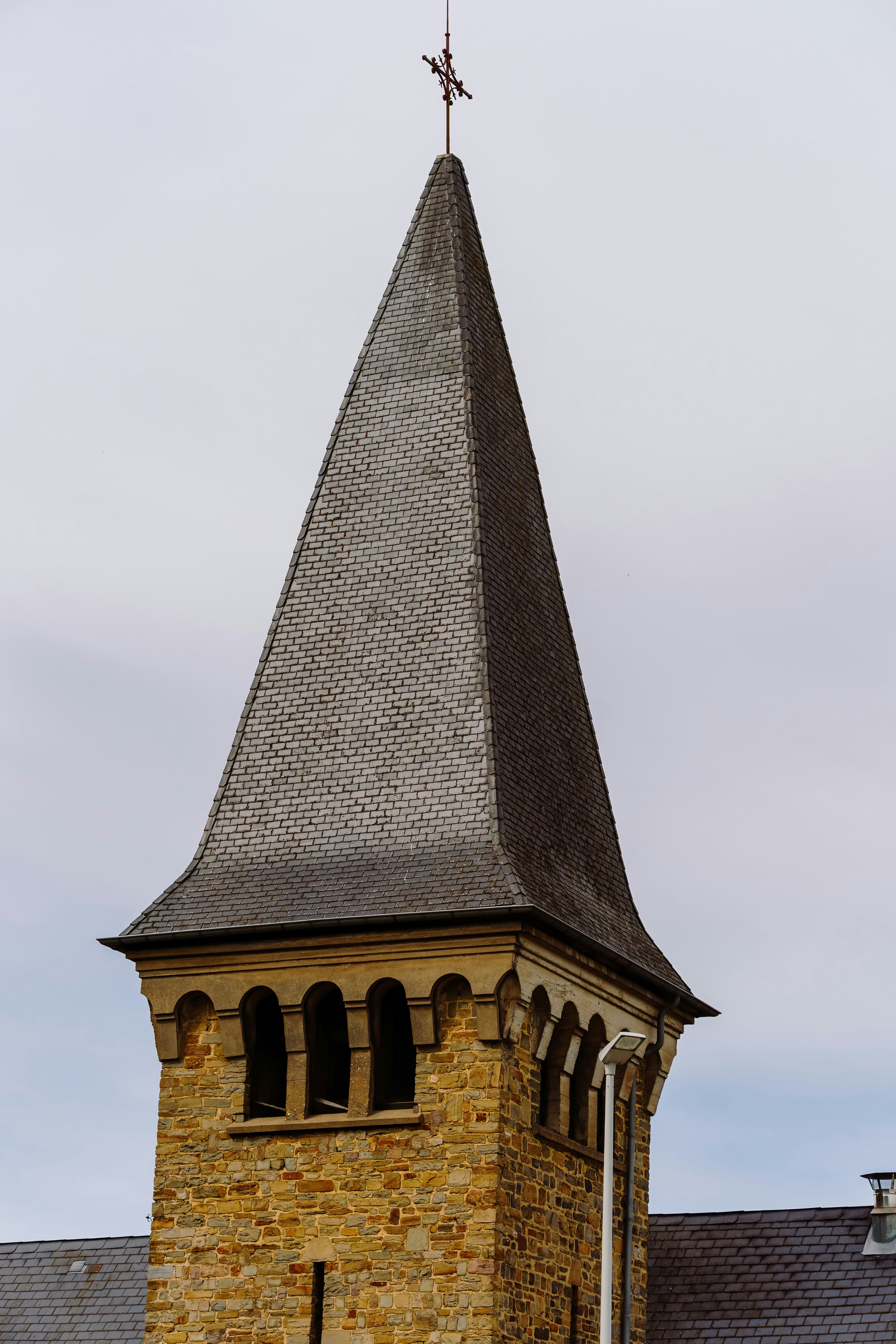 A Leaning Spire of Time: Brick Tower Against a Pale Sky