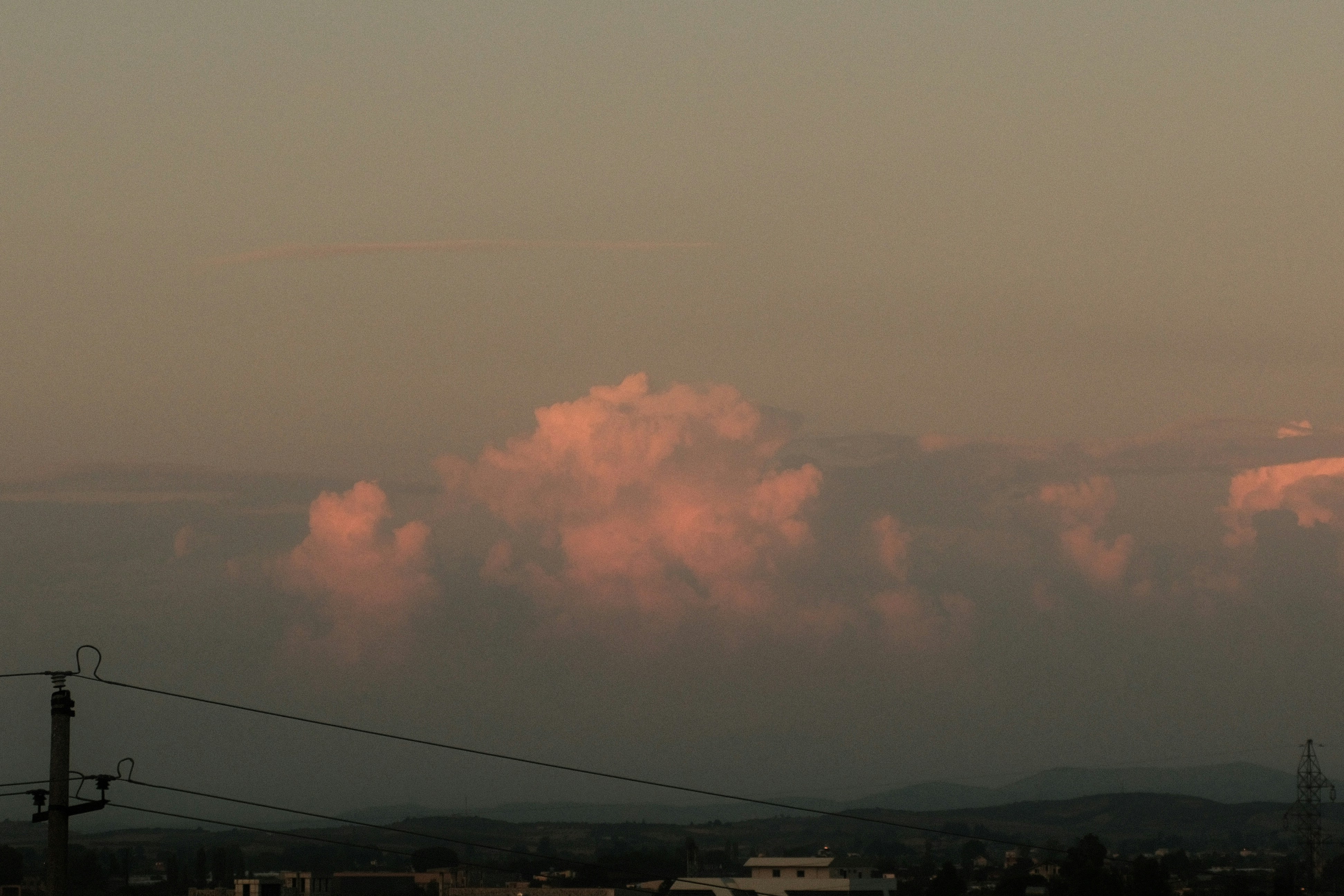 Calm Horizon: Clouds Cast Warm Glow Over Suburban Lowlands