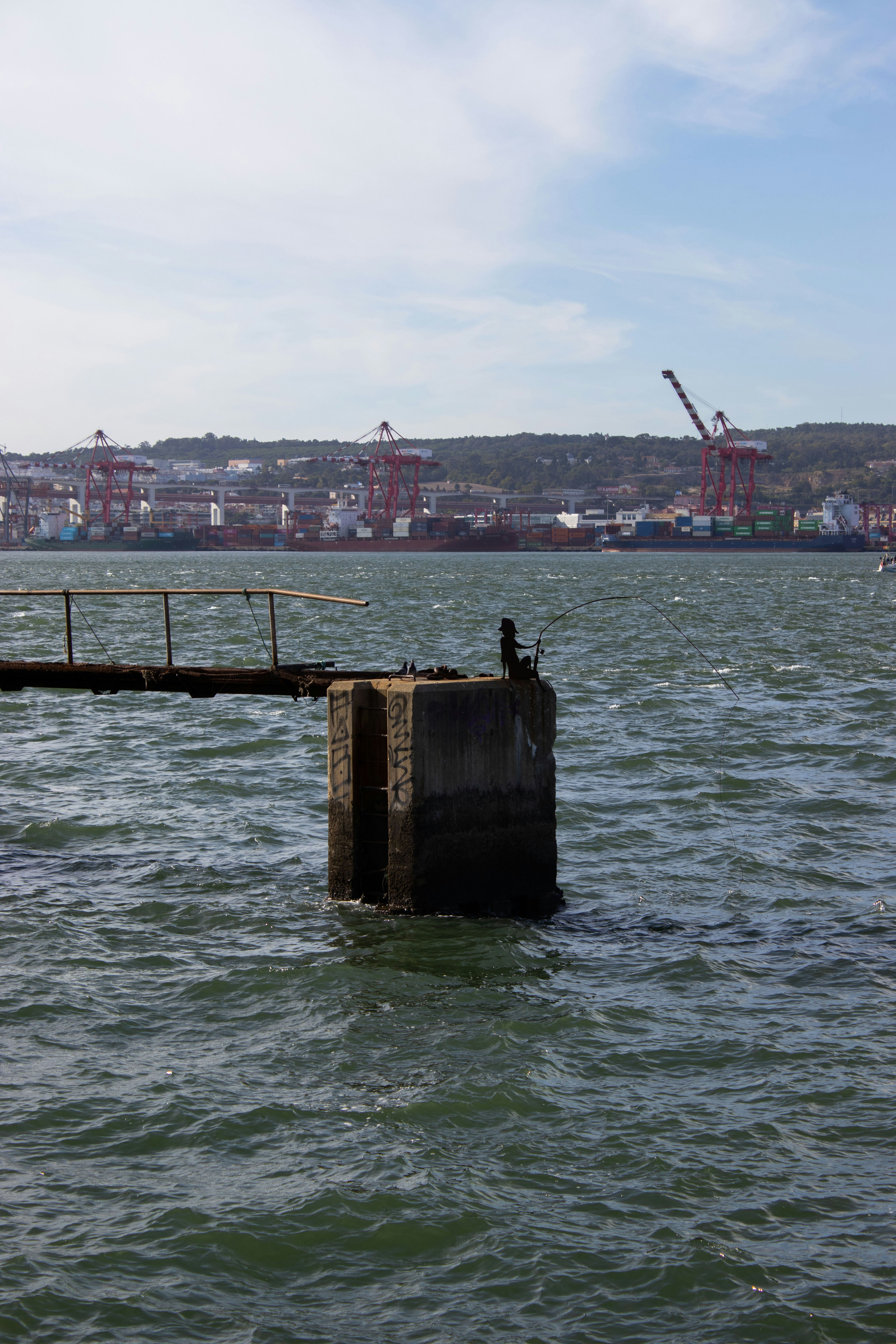 Pier of Solitude: A lone figure guardian on the concrete anchor