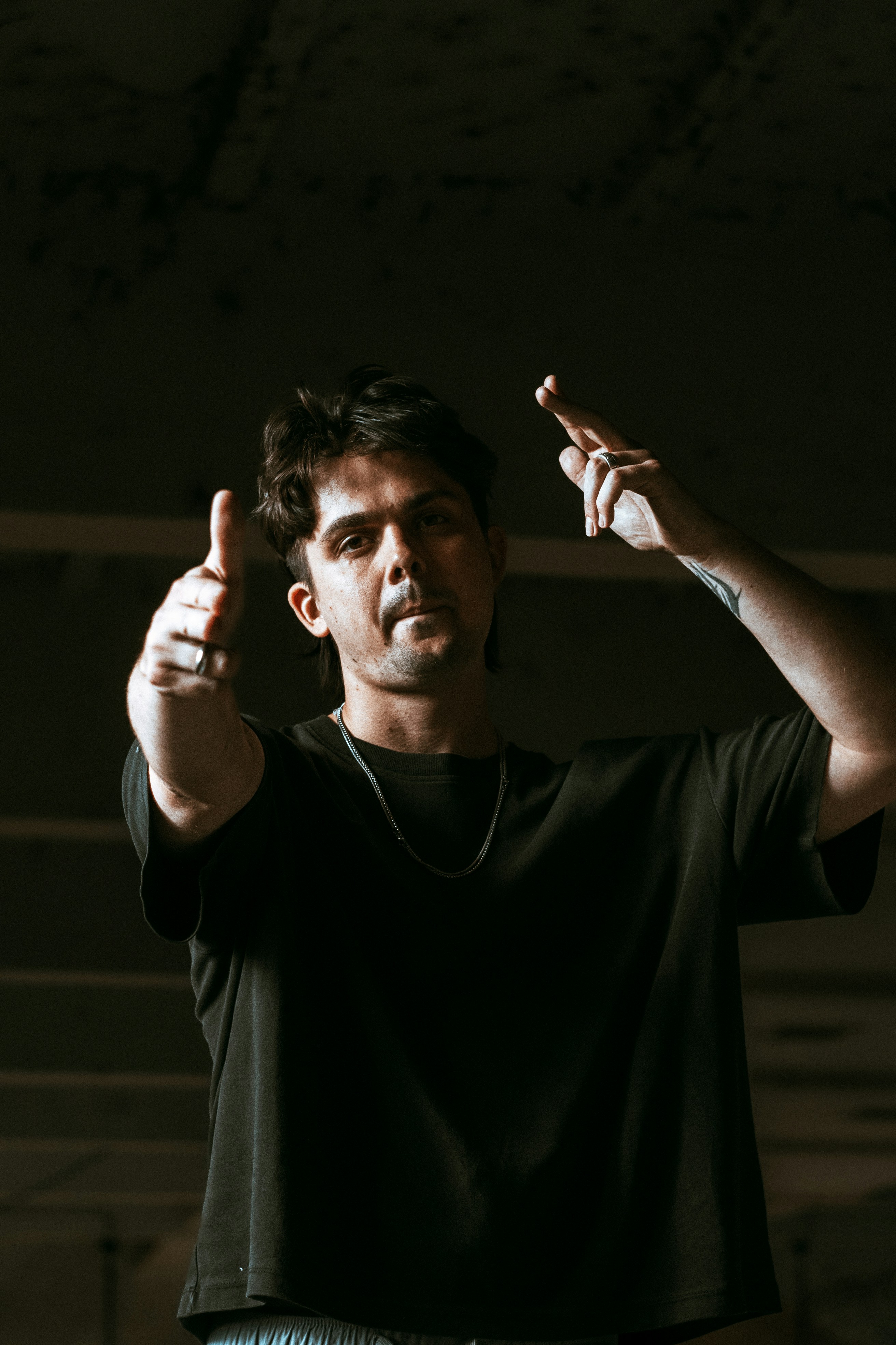 Hands Up, Spotlight Down: A Gritty Portrait in Low Light