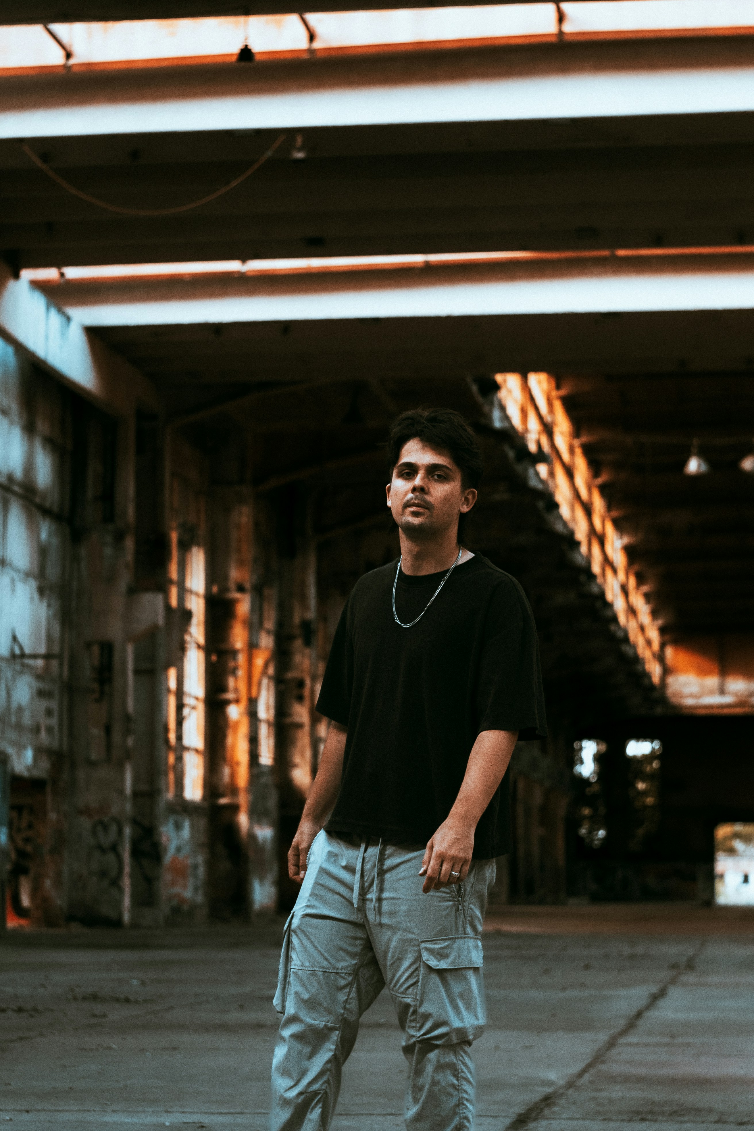 Under Neon Rails: A Quiet Portrait in a Distant Warehouse
