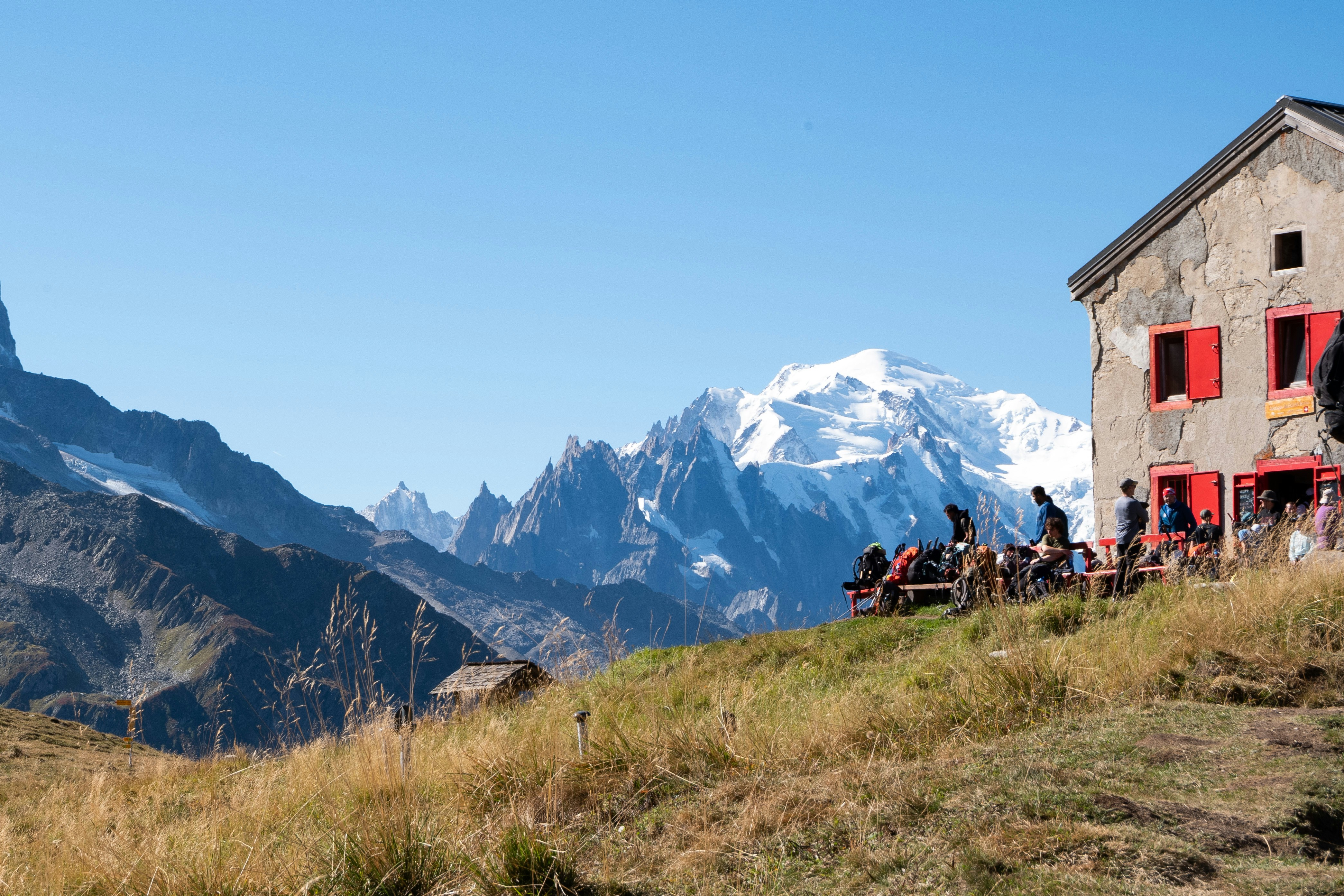 Alpine Refuge: Red-windowed House Framed by Peaks