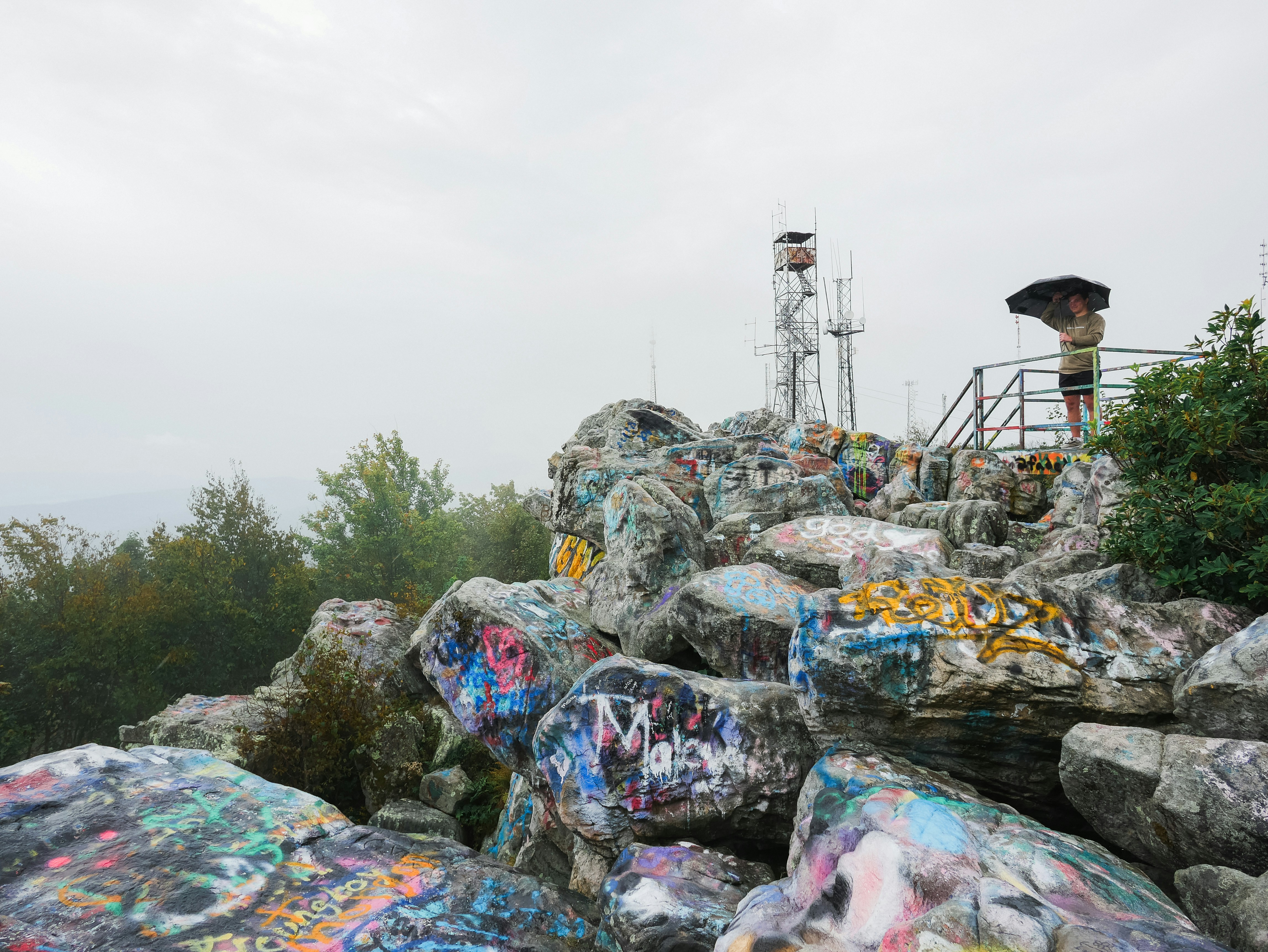 Graffiti-laden Rocks Beneath a Lookout with a Lone Umbrella