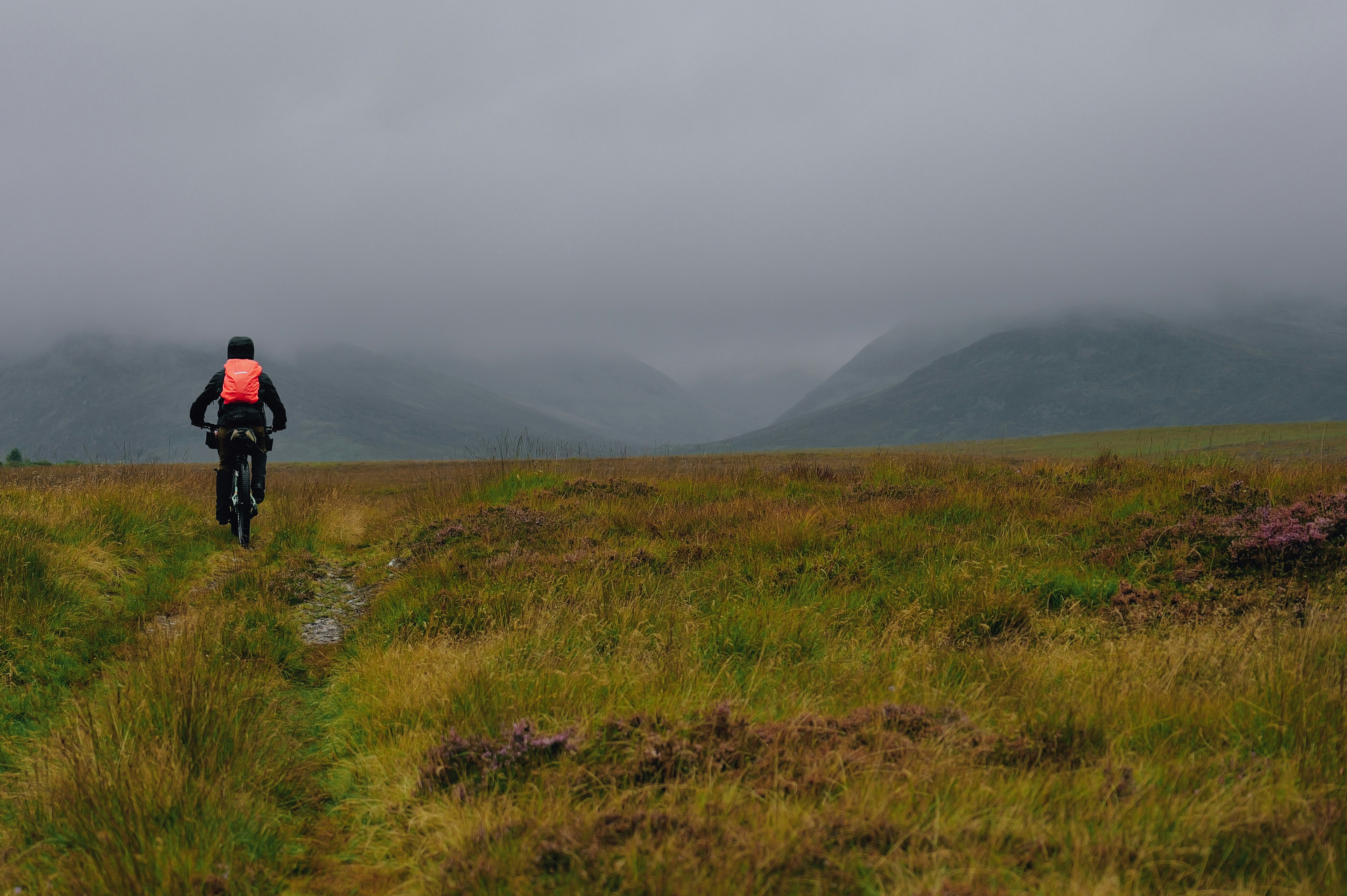 Ridgebound Ride: Lone Cyclist Presses Toward Misty Horizons