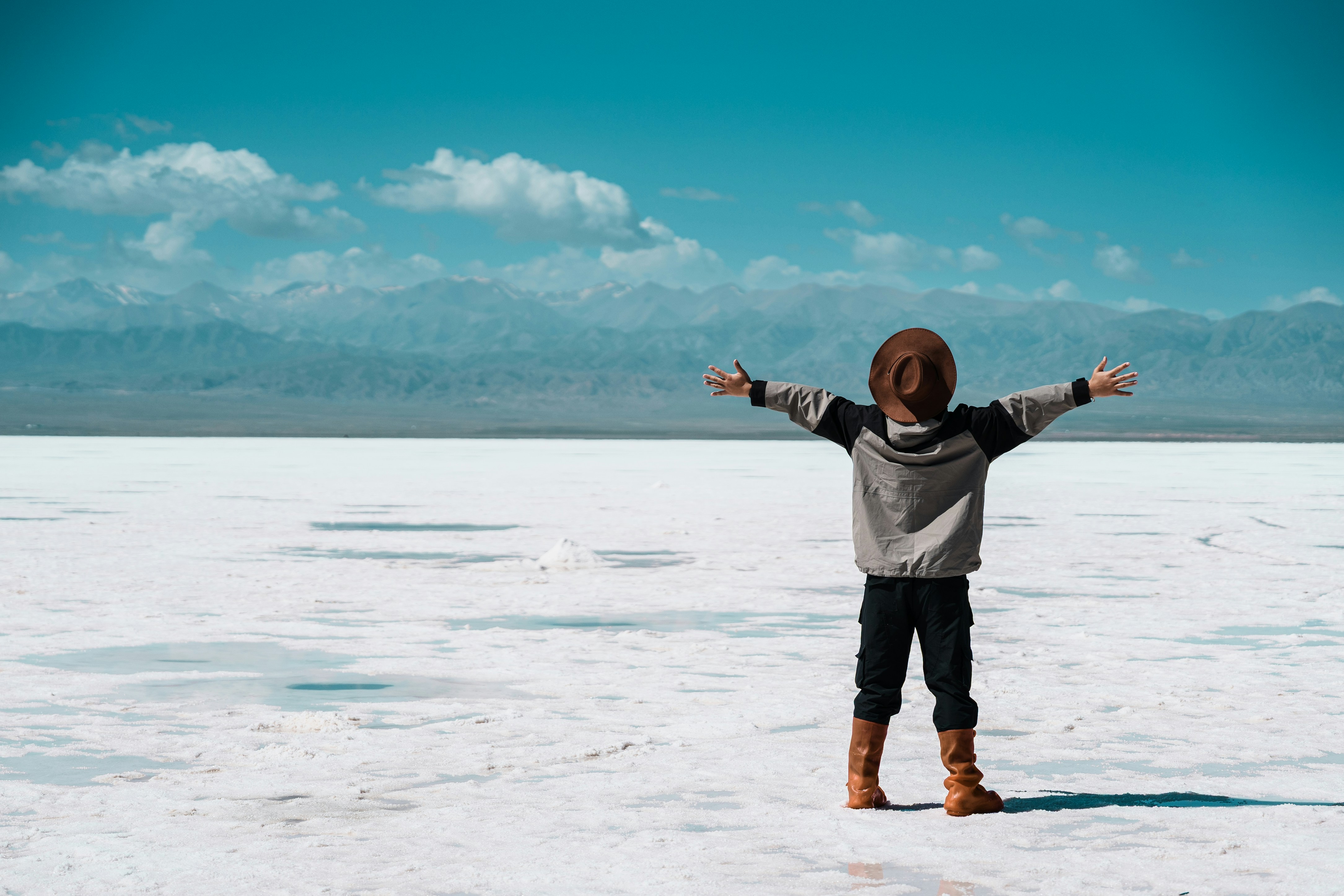 A Silhouette of Freedom: Child with Open Arms in a Vast Salt Plane