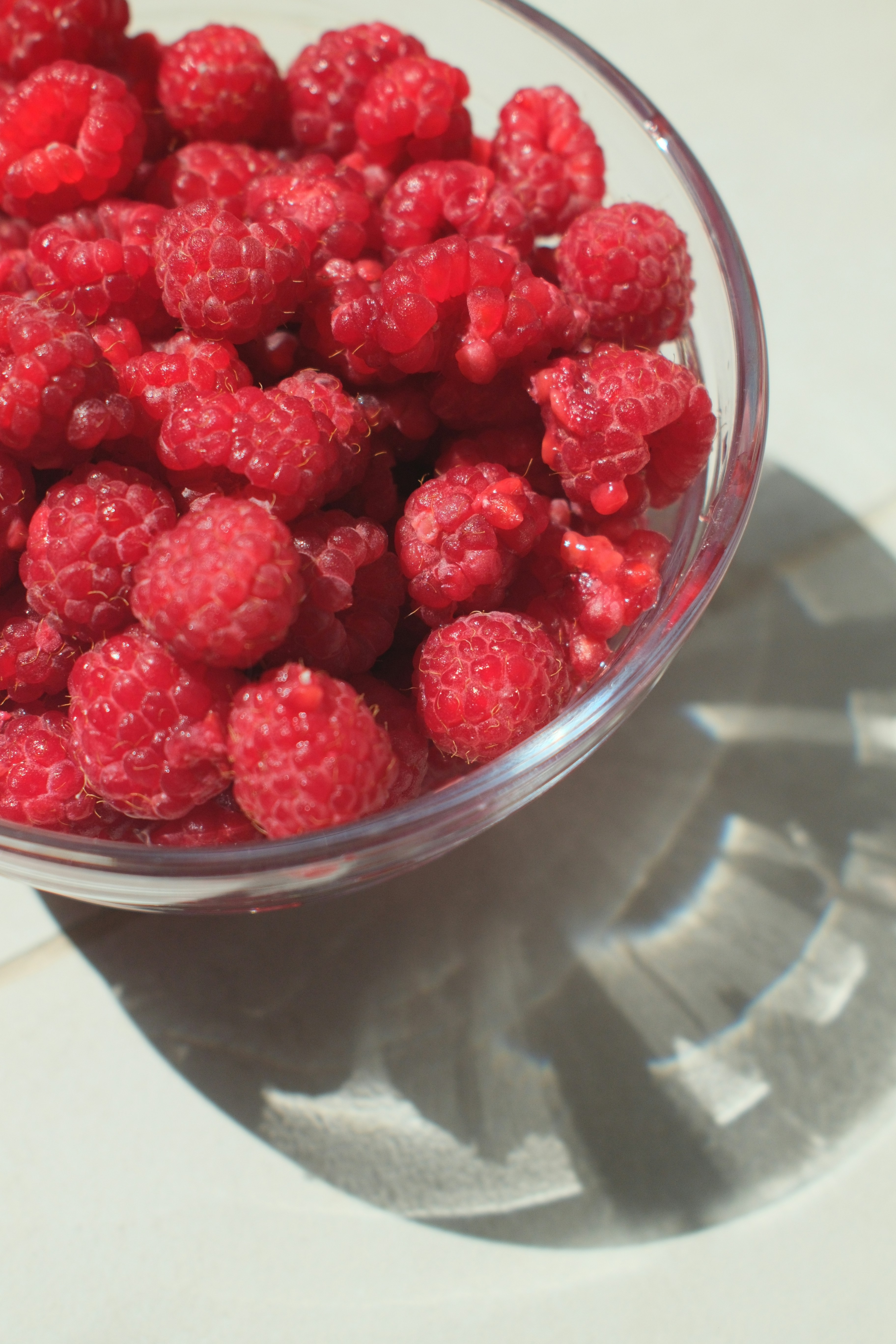 Crimson Berries in Glass Bowl: Sunlit Raspberry Moment